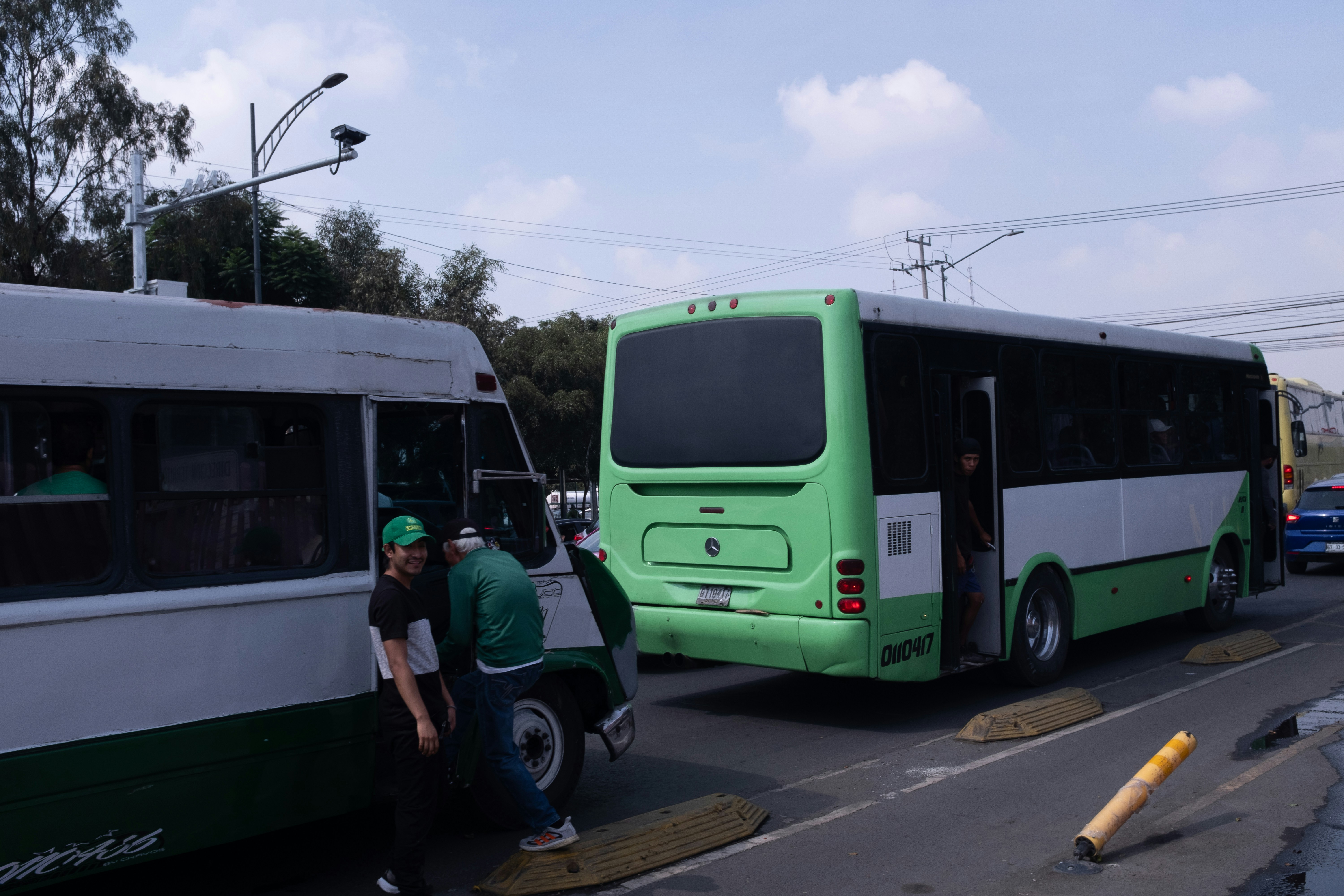 Emerald Green Bus Idle at the Curb: A Street-Side Transit Moment