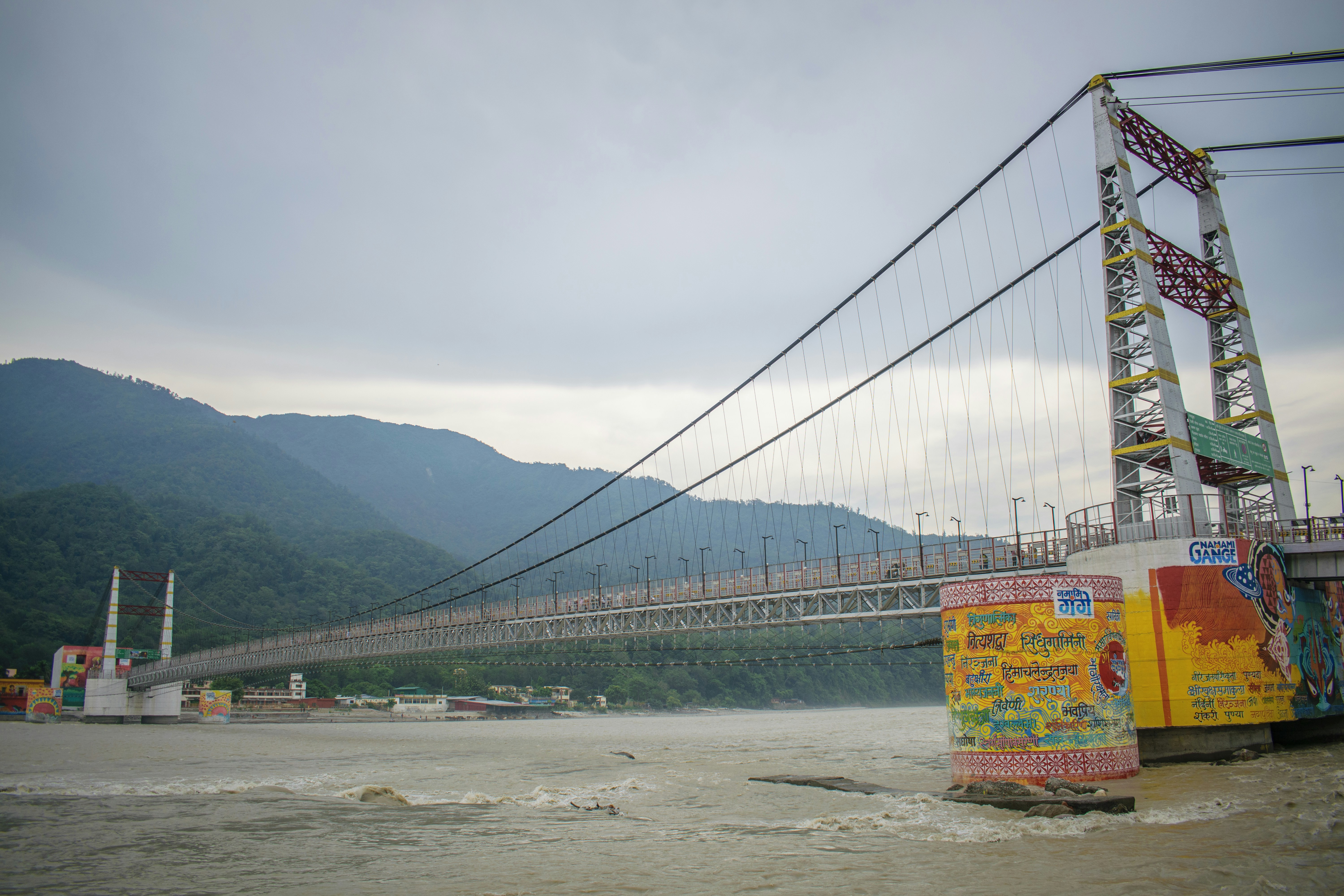 Colorful Pillars Meet Steel Span: A River Bridge Framed by Mountain Mist