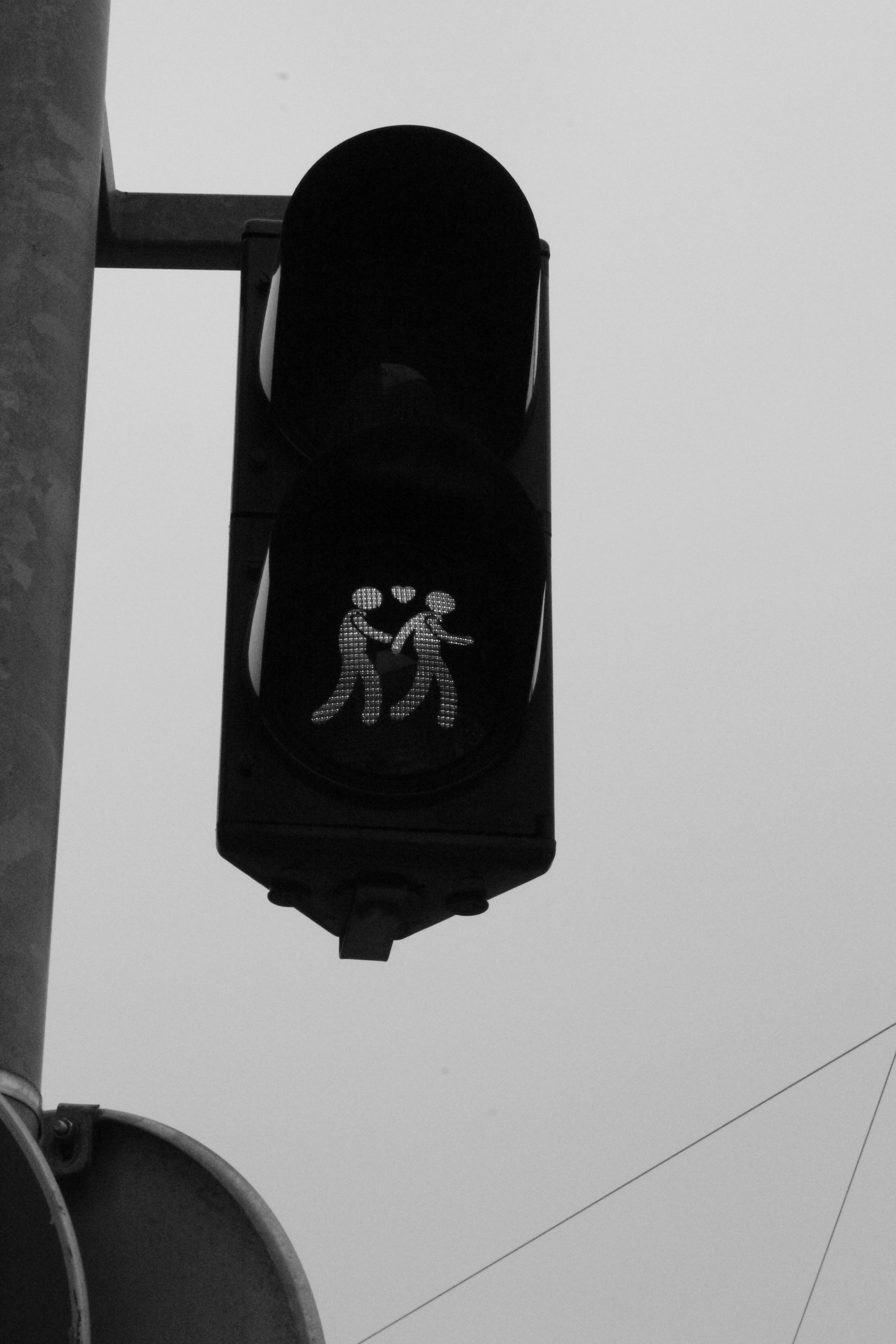 Monochrome Crossing: Two Figures Holding Hands in a Quiet Pedestrian Signal