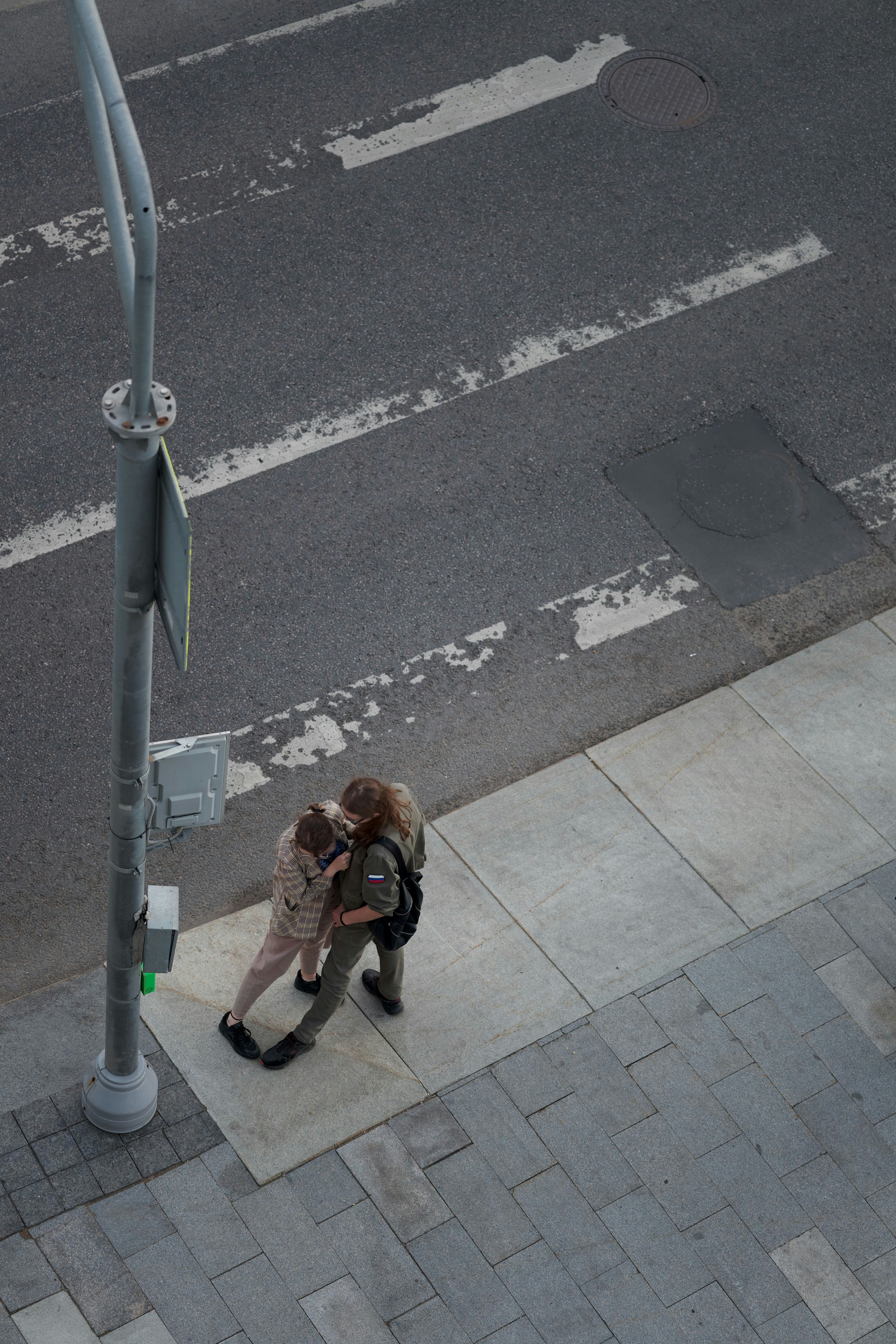 Two people embrace on the sidewalk. photo – Free Image on Unsplash