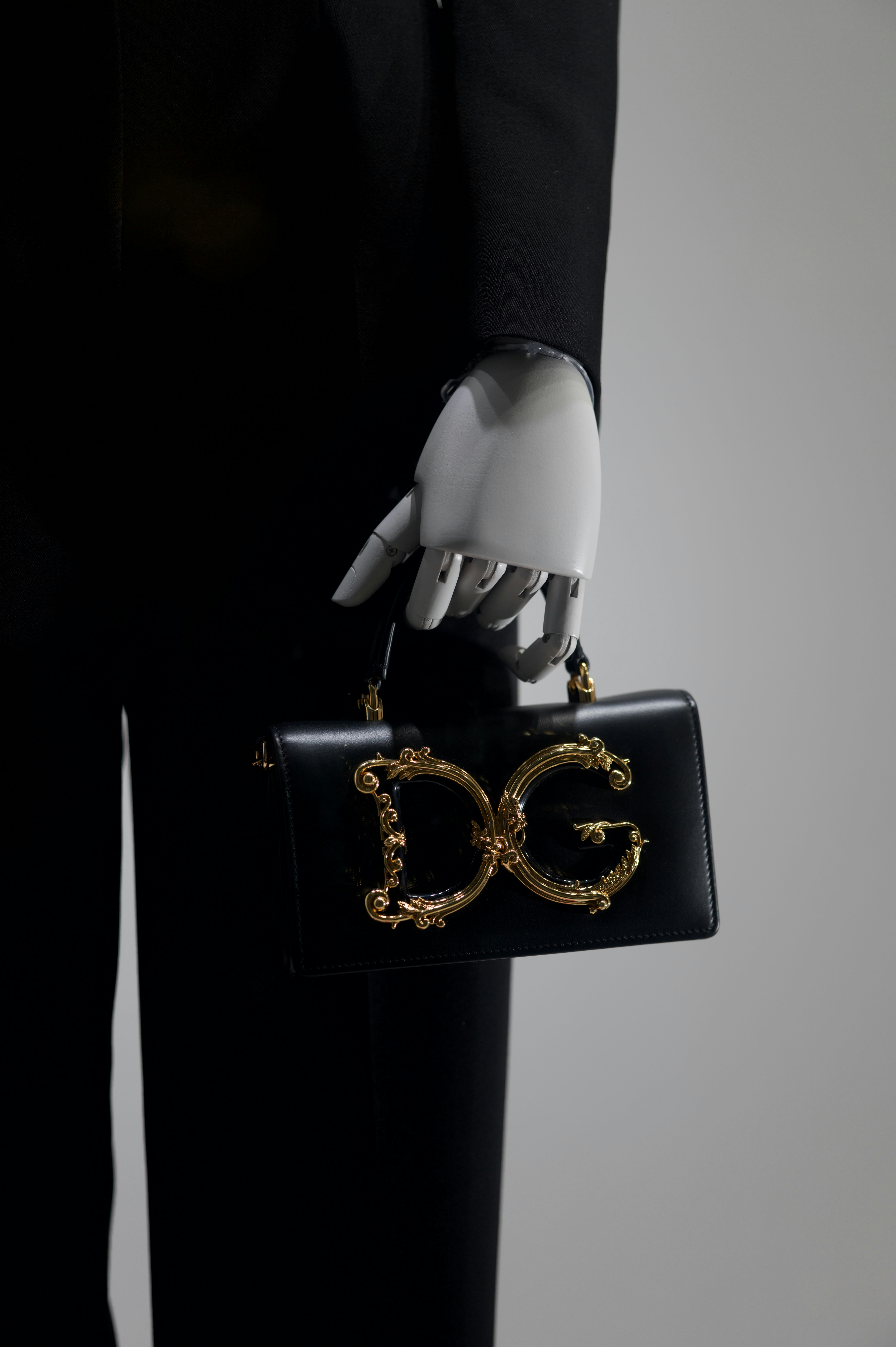 A mannequin holds a dolce & gabbana handbag.