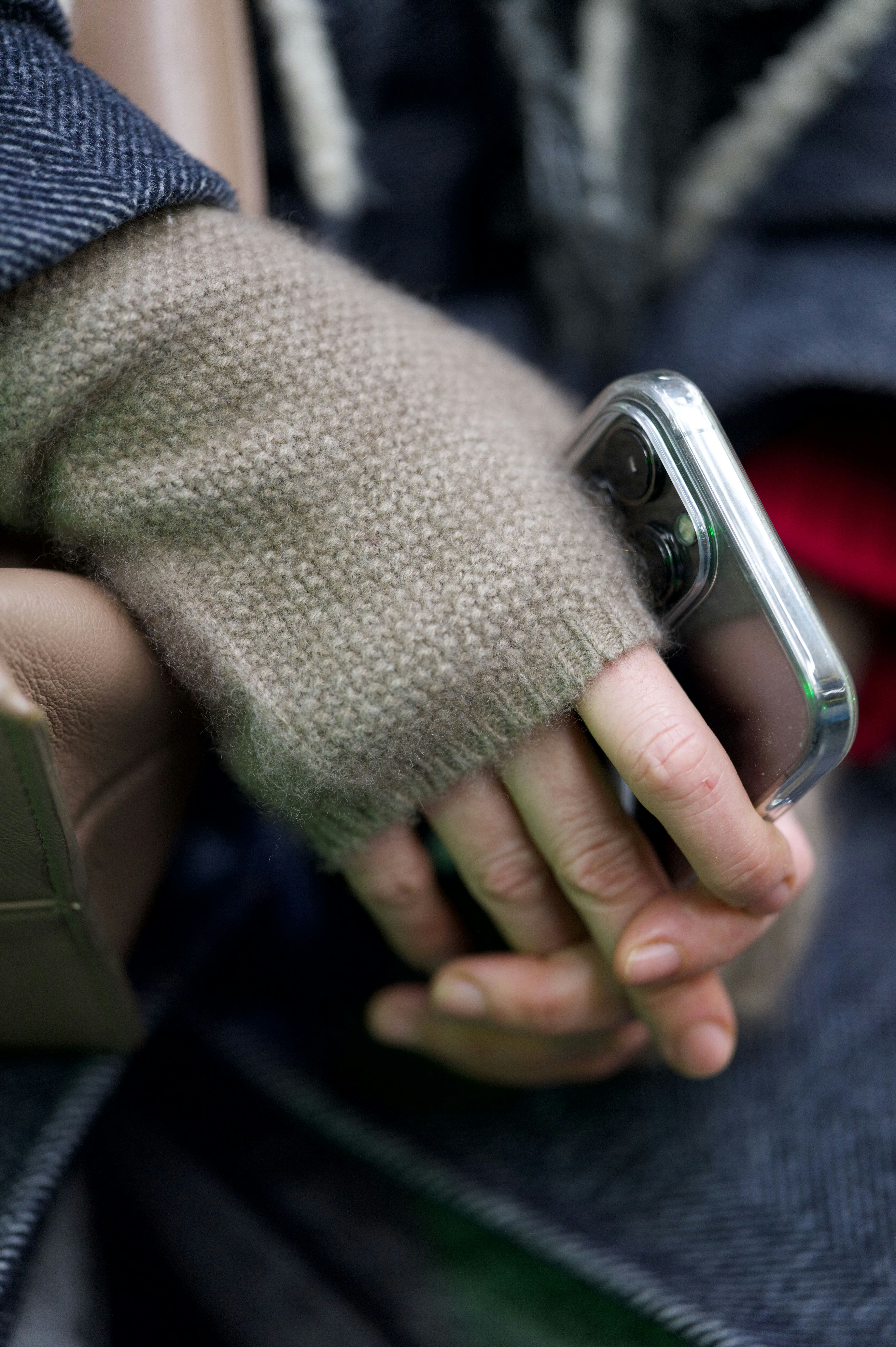 Cozy grip: close-up of gloved hands clutching a smartphone