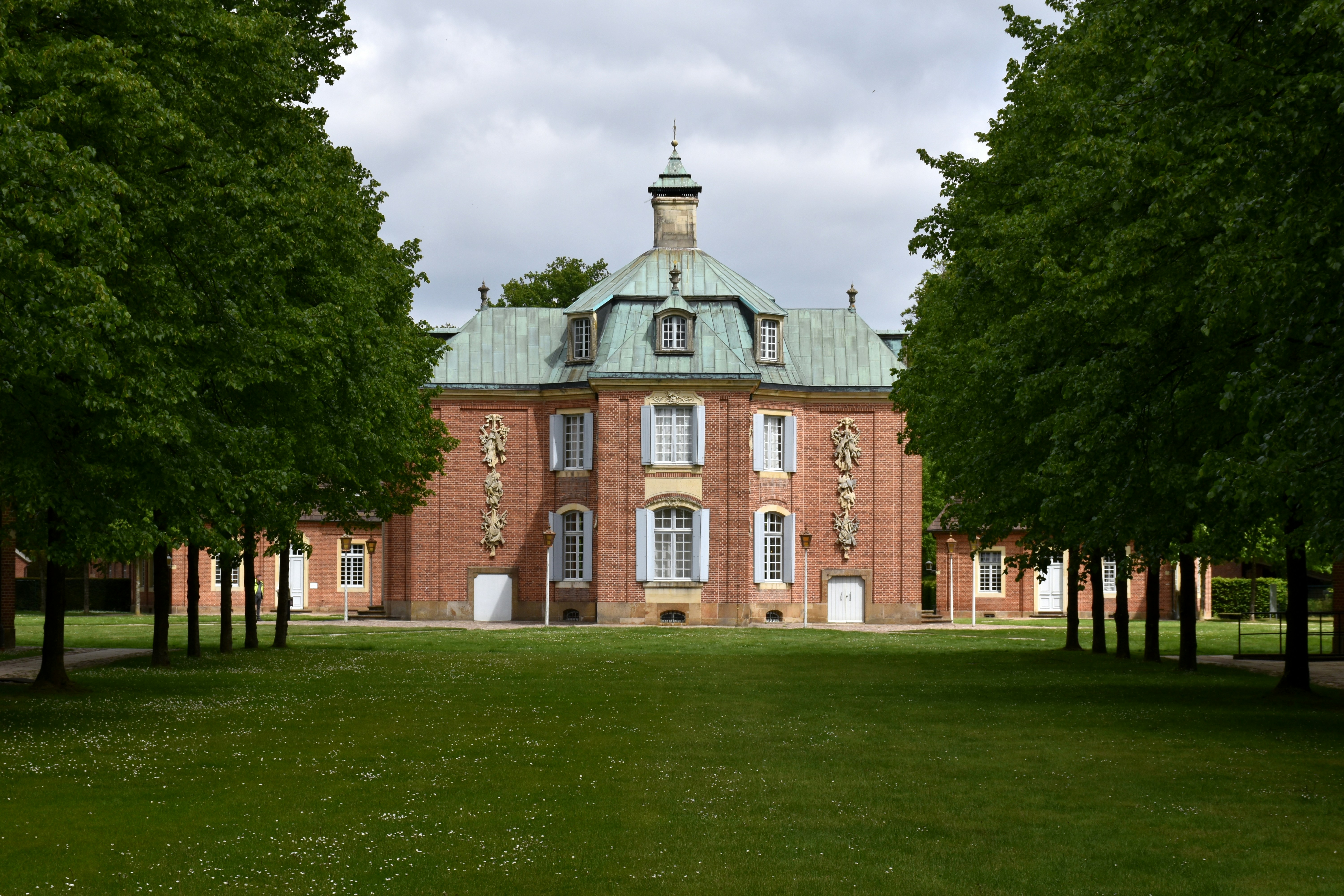 A stately brick building is framed by trees. photo – Free Building ...