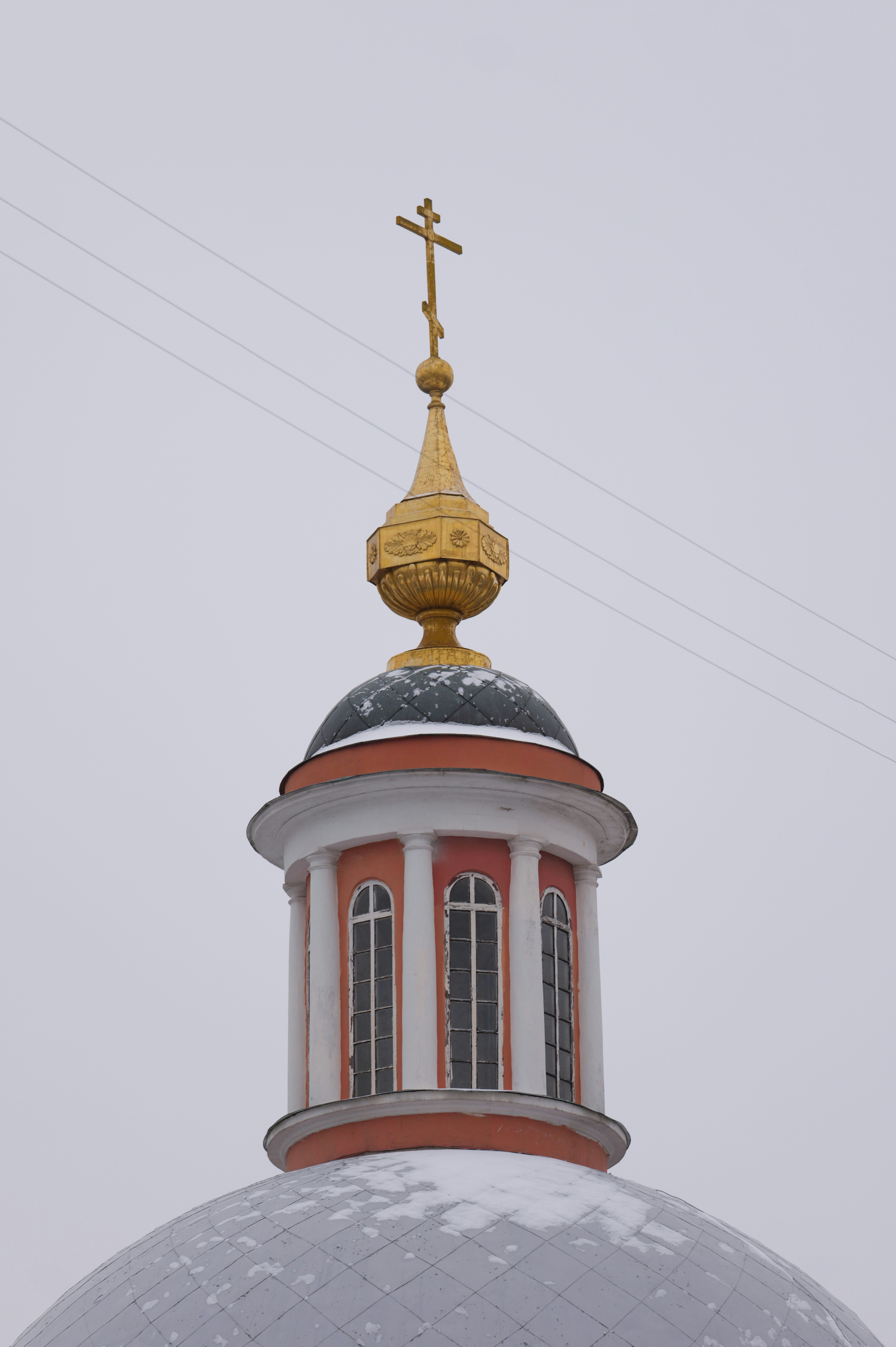 A church dome with a golden cross sits.