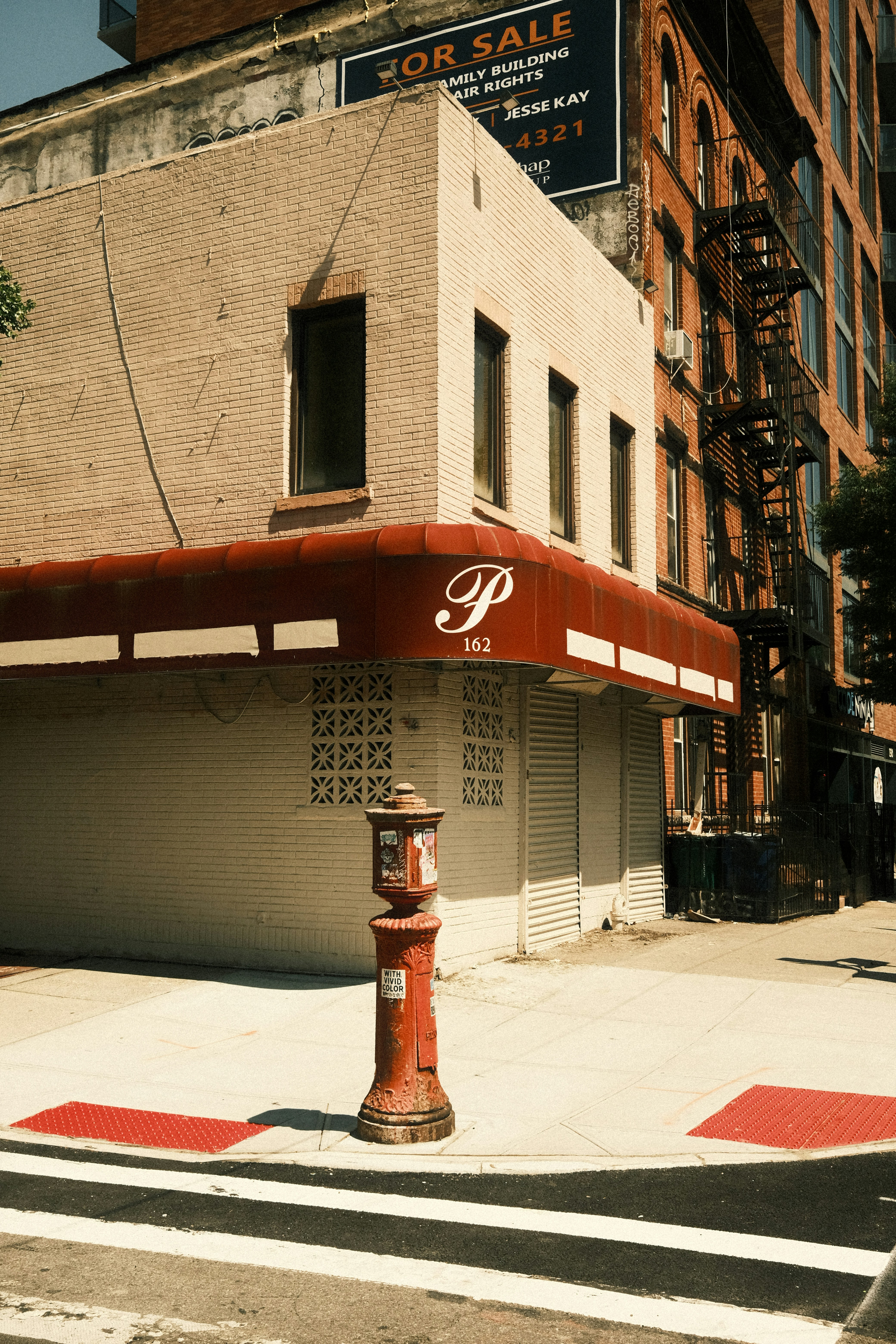 A building with a red awning and fire hydrant. photo – Free Street ...