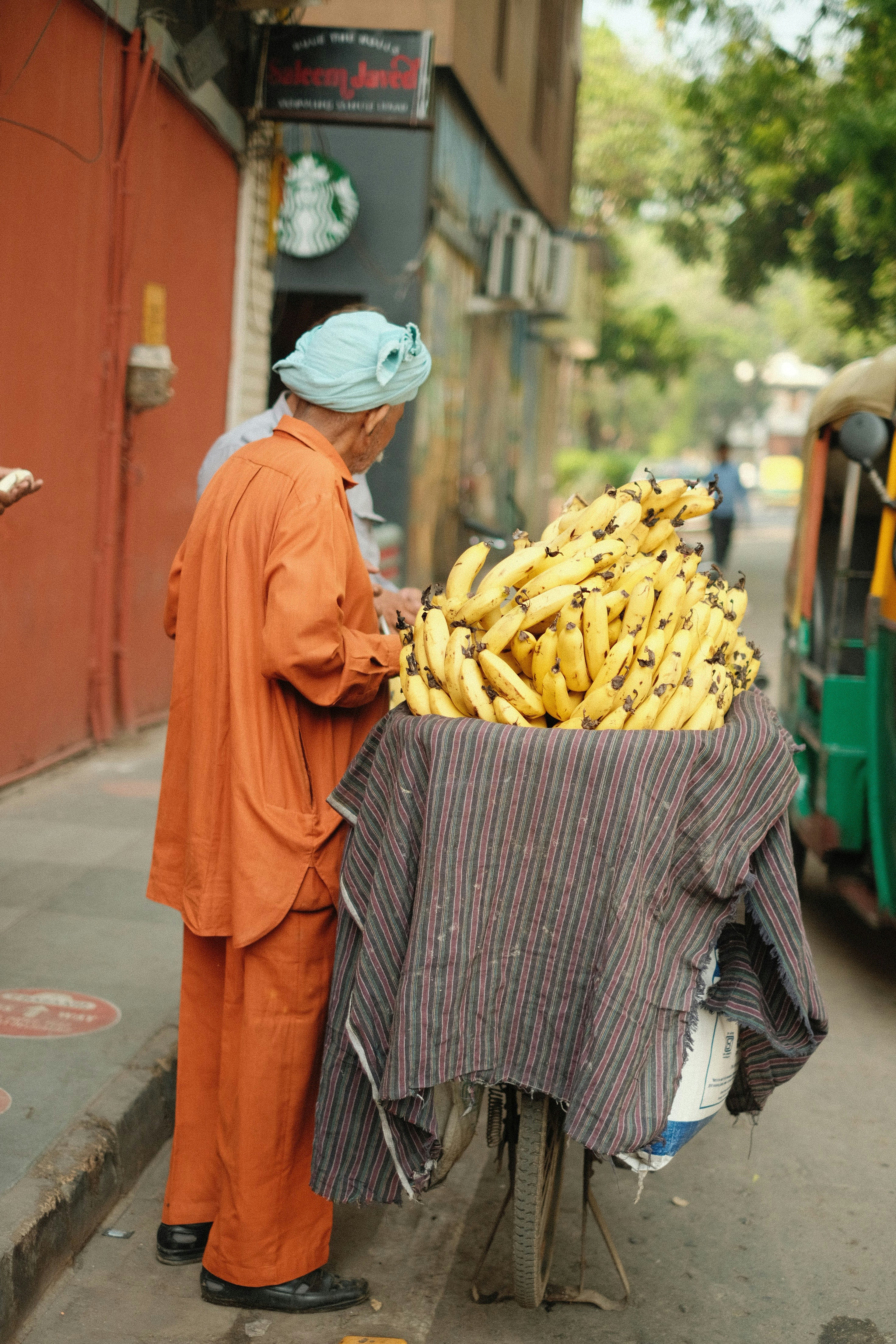 Man sells bananas on a street.
