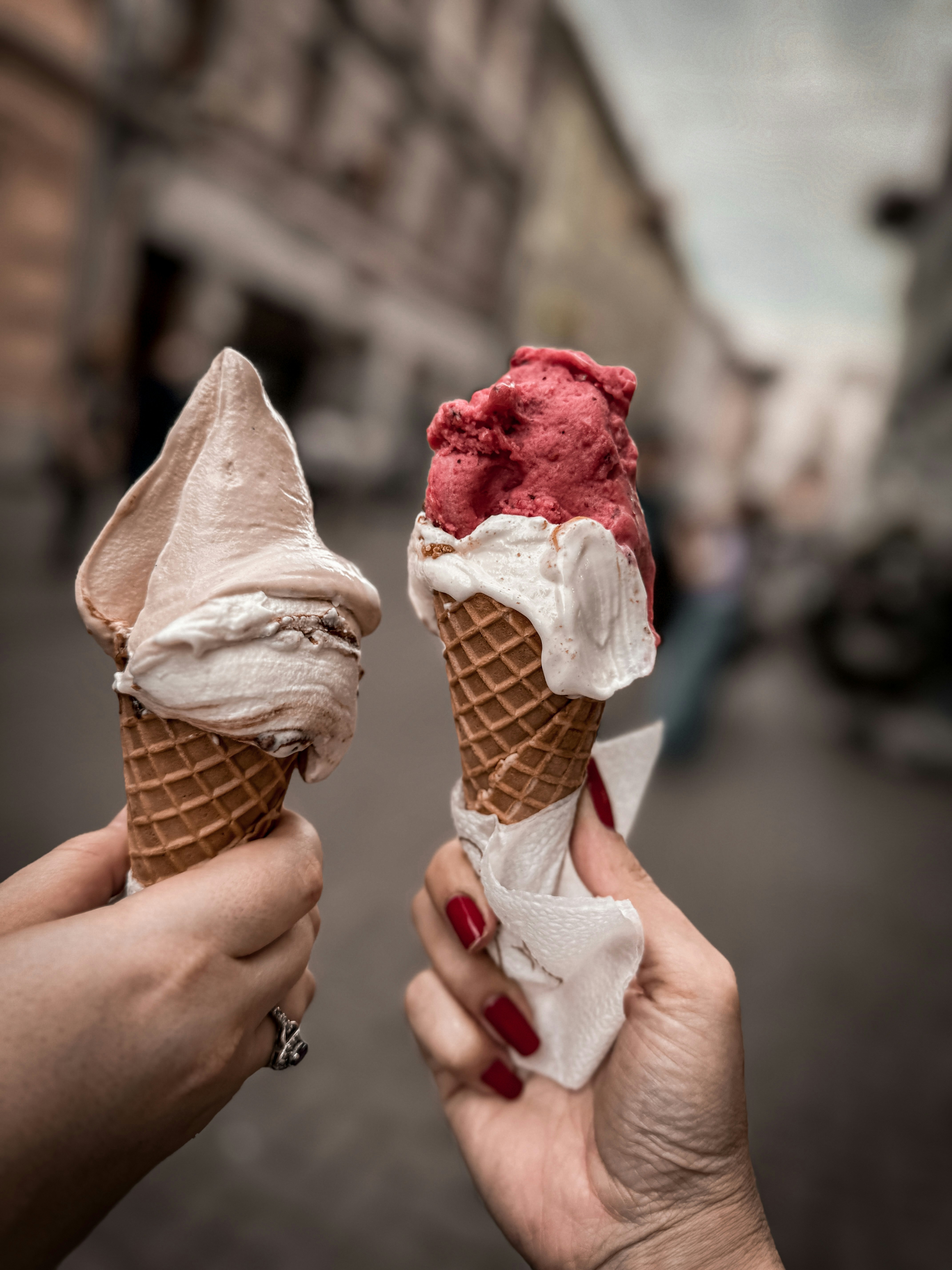 City Street Duo: Gelato Cones in Sharp Focus Amid a Blurred Urban Backdrop