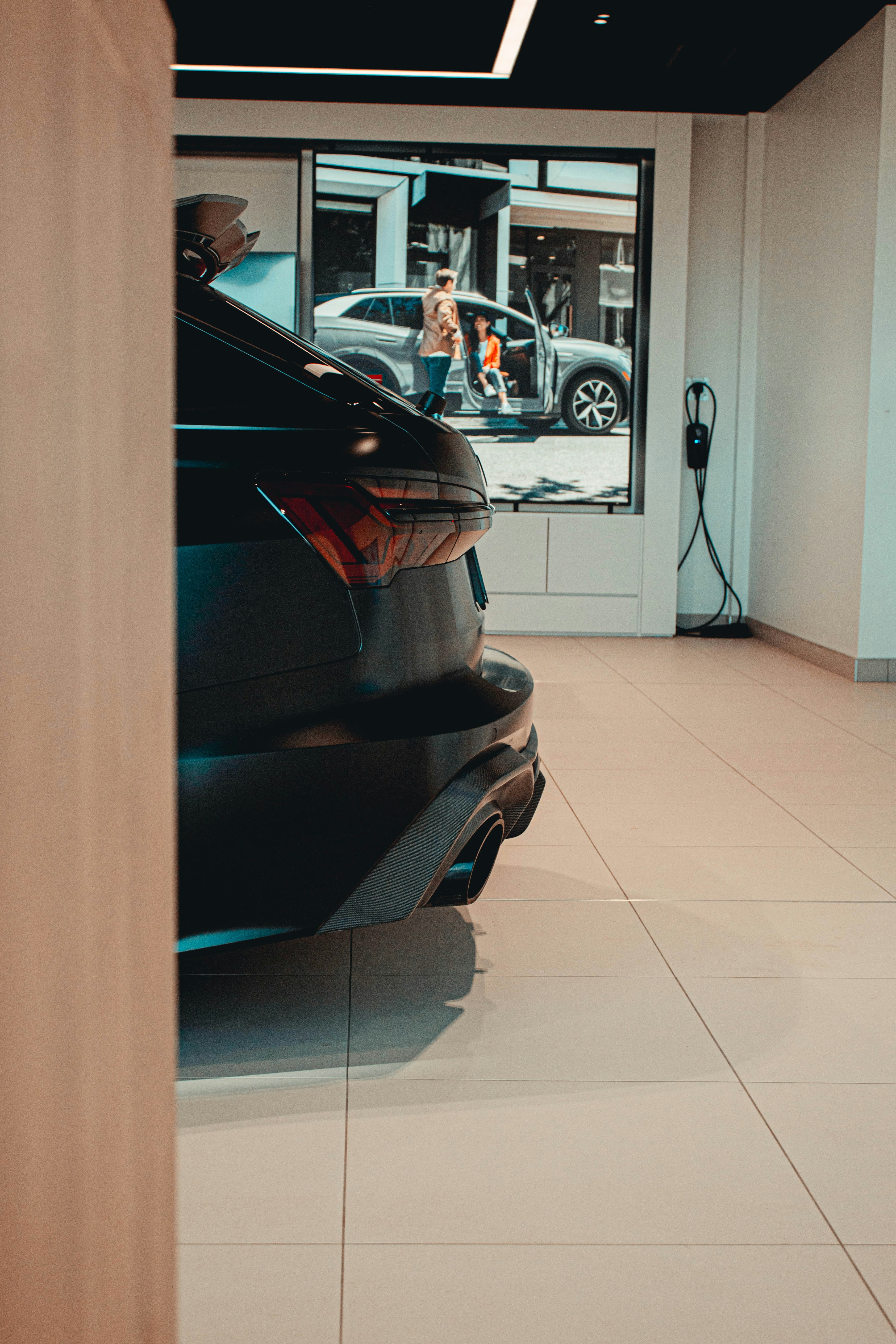 Midnight Contour in a Bright Showroom: A Black Sedan Stages Its Quiet Poise