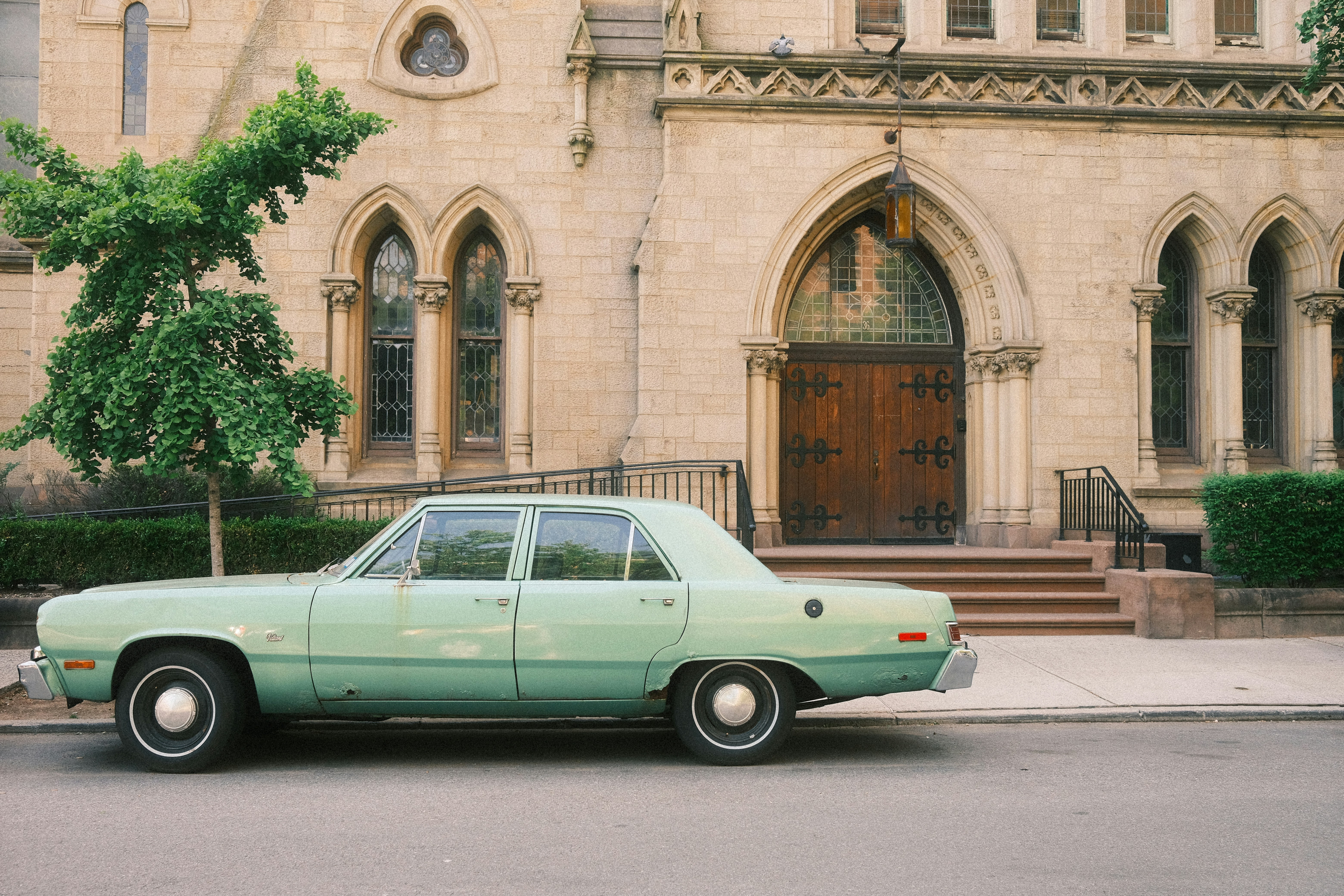 Pastel Cruiser Beside a Gothic Facade