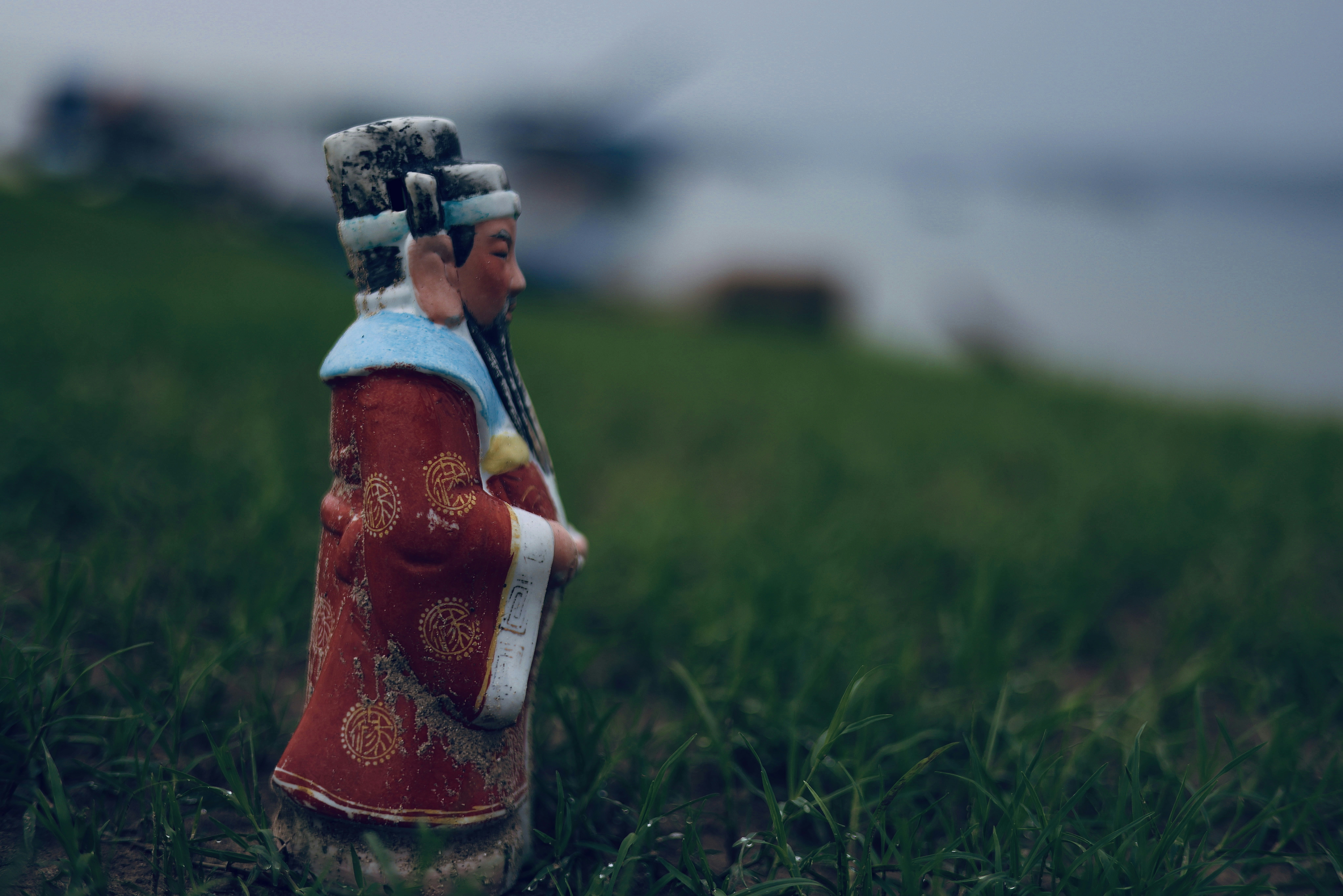 Miniature Matryoshka, Big Quiet: A Closer Look at a Tiny Figure Amid Grass