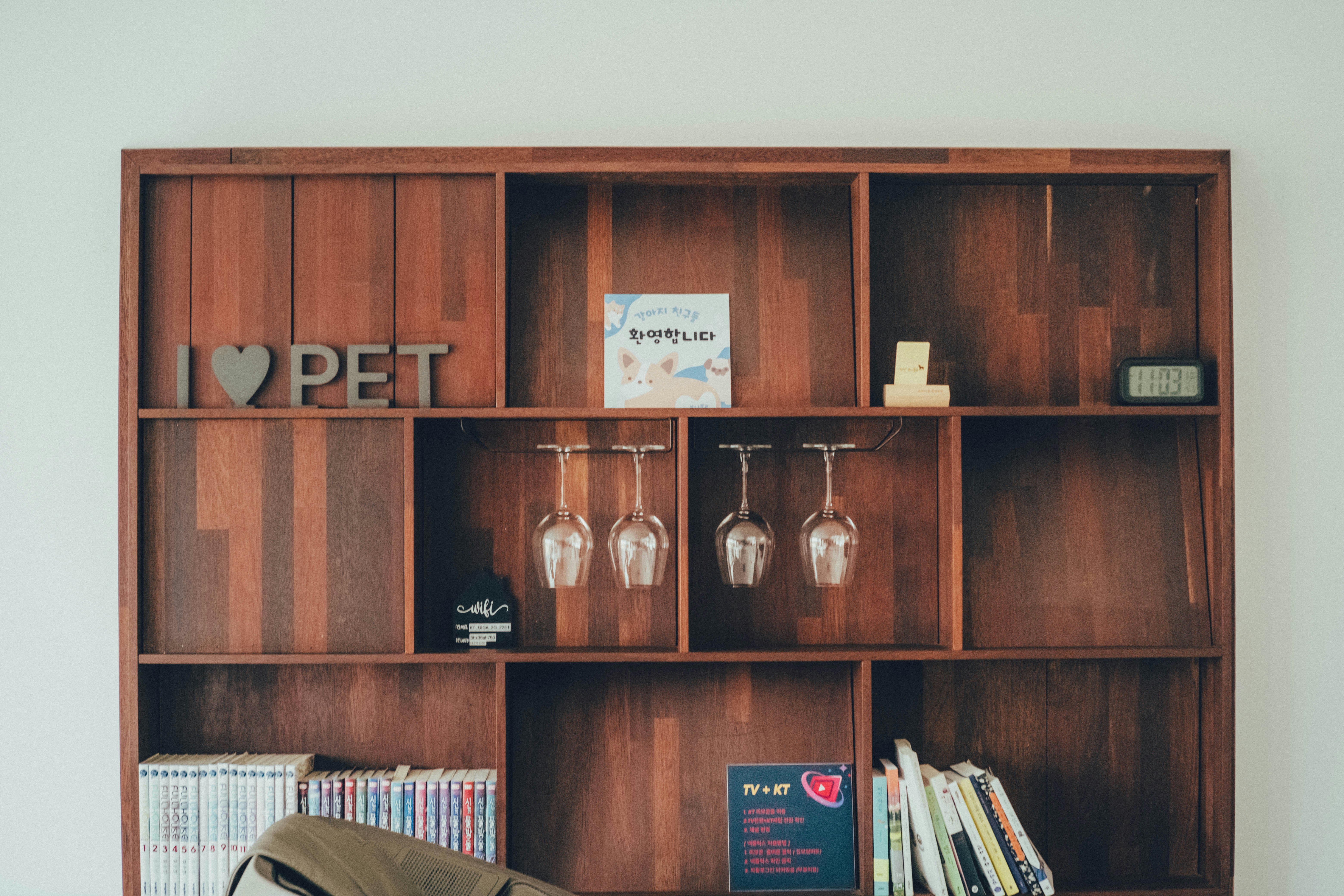 I Heart PET Above Glass-Hung Shelves in a Quiet Wooden Nook