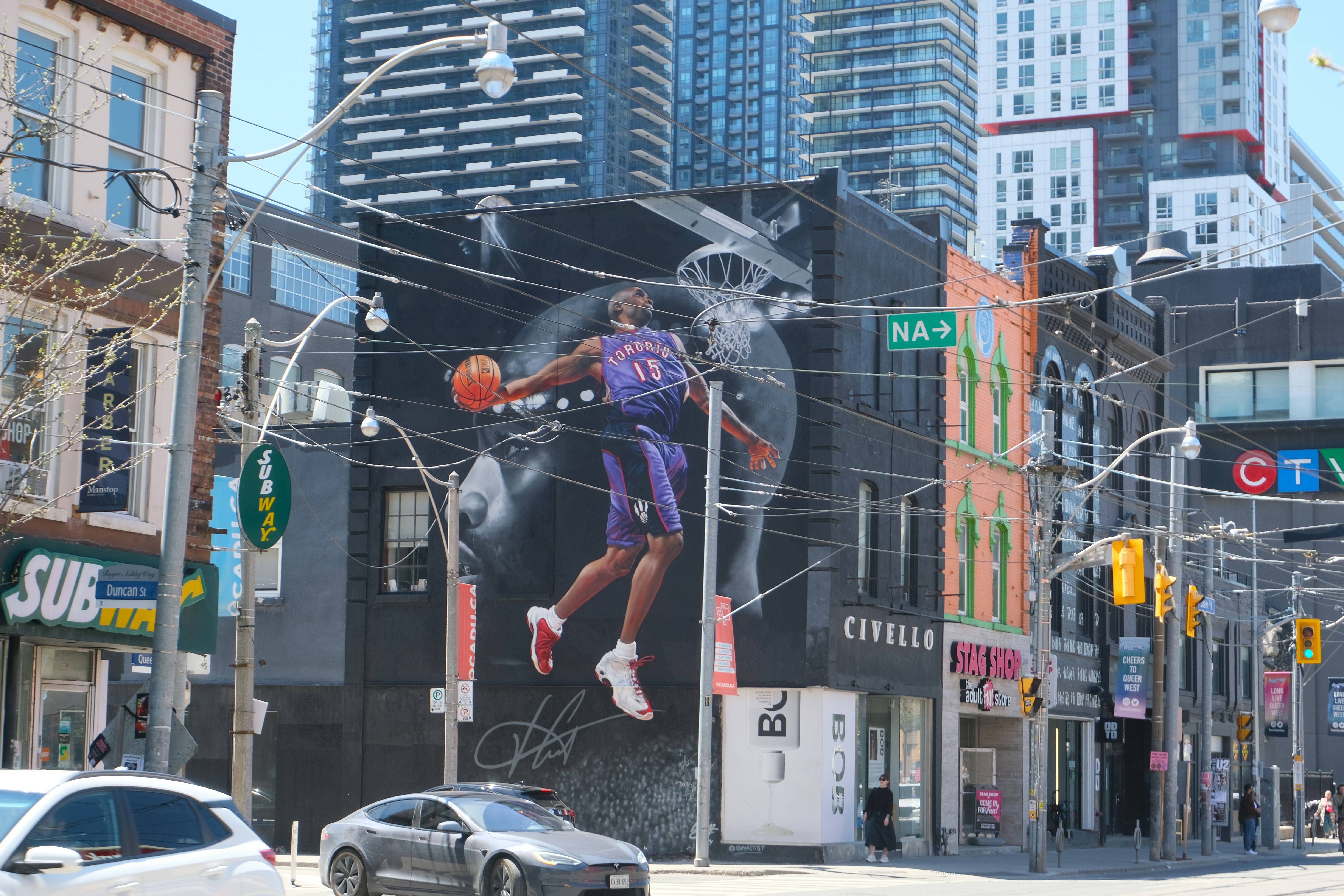 A vibrant mural of a basketball player soaring through the air, set against the backdrop of a bustling cityscape. The artwork celebrates urban sports and artistry.