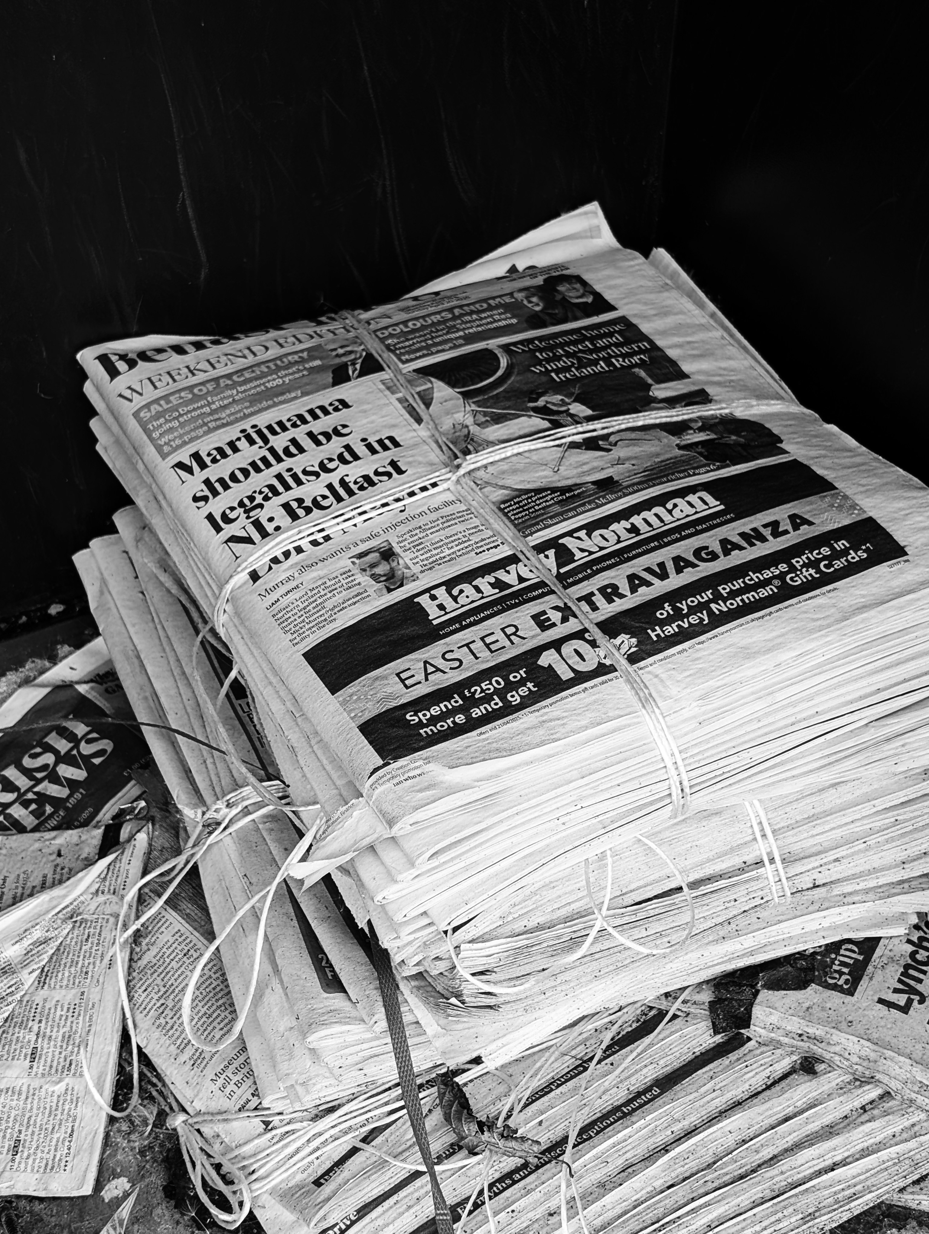 Stack of bundled newspapers showcasing headlines on current events, emphasizing the role of print media in shaping public discourse.