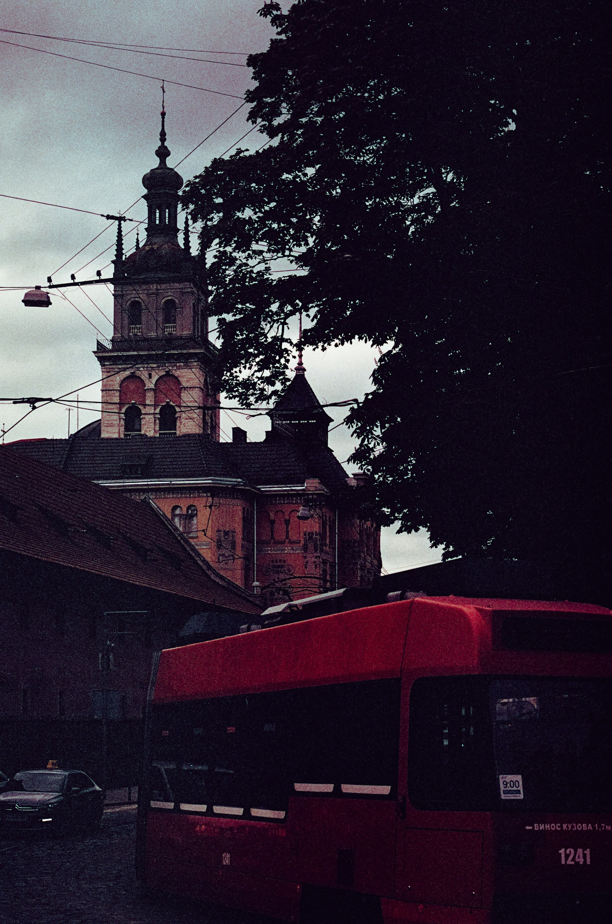 A red bus passes a historic building. photo – Free Image on Unsplash