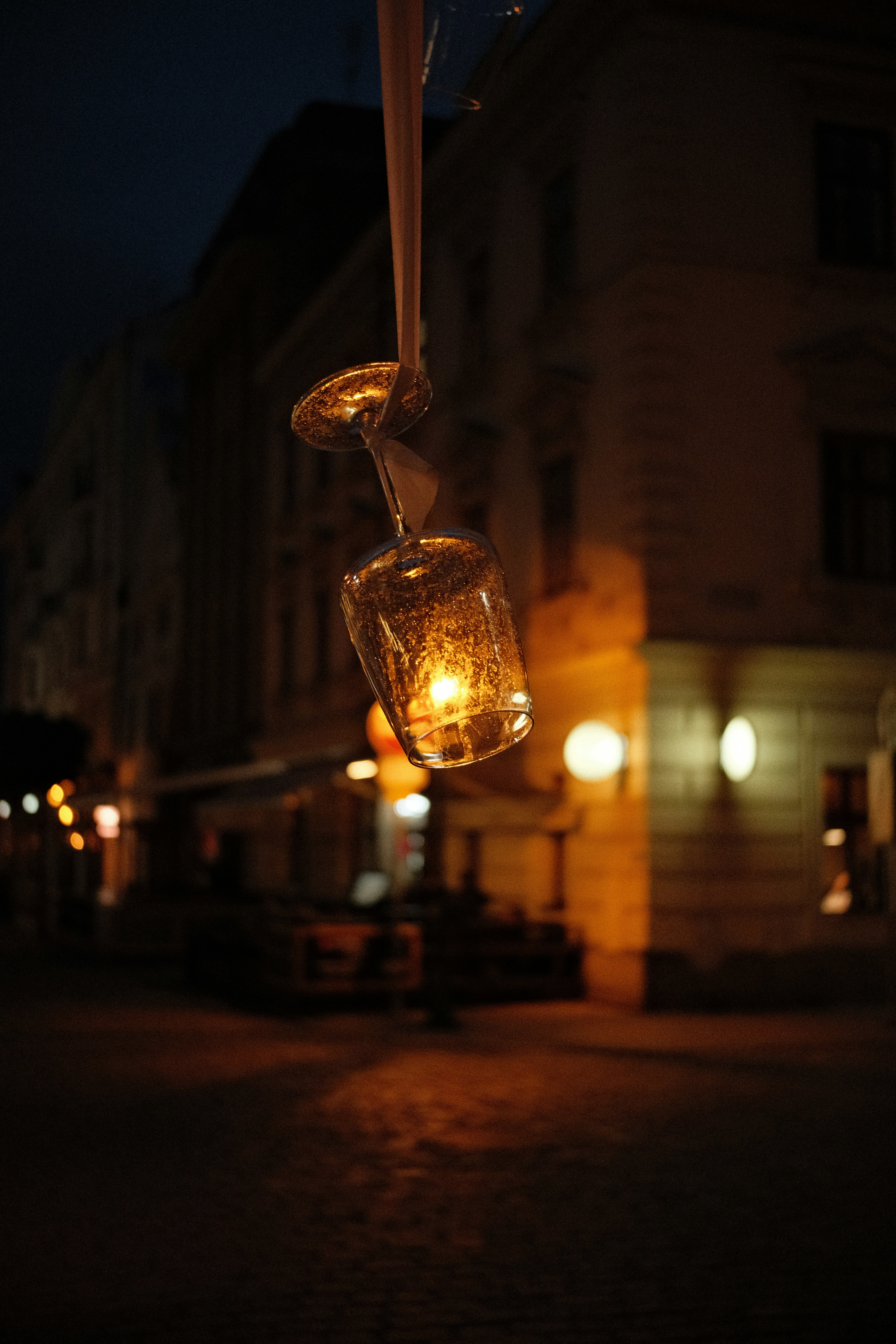 Amber Lanterns Hover Over a Quiet Cobblestone Street