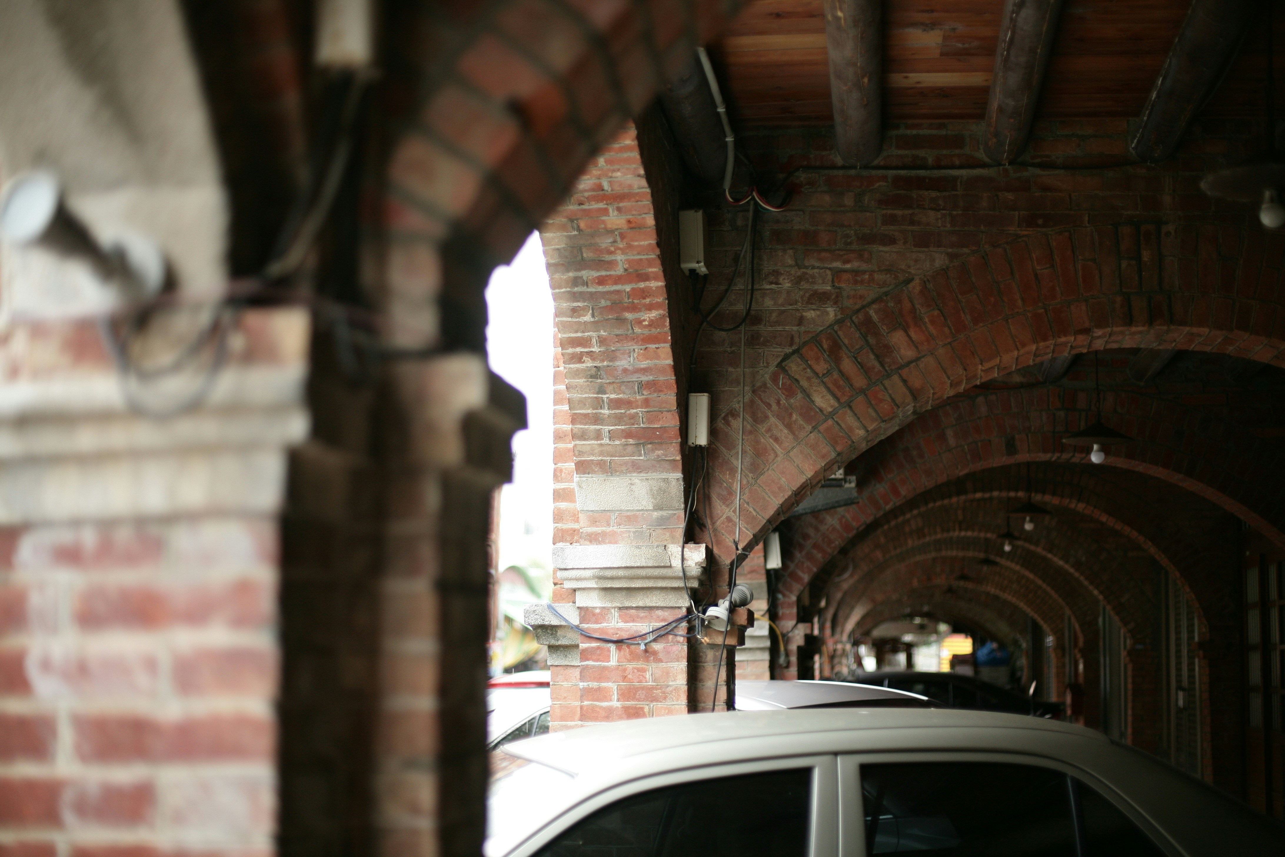 Car in a Brick-arched Arcade: Quiet Rhythm of Repeating Vaults