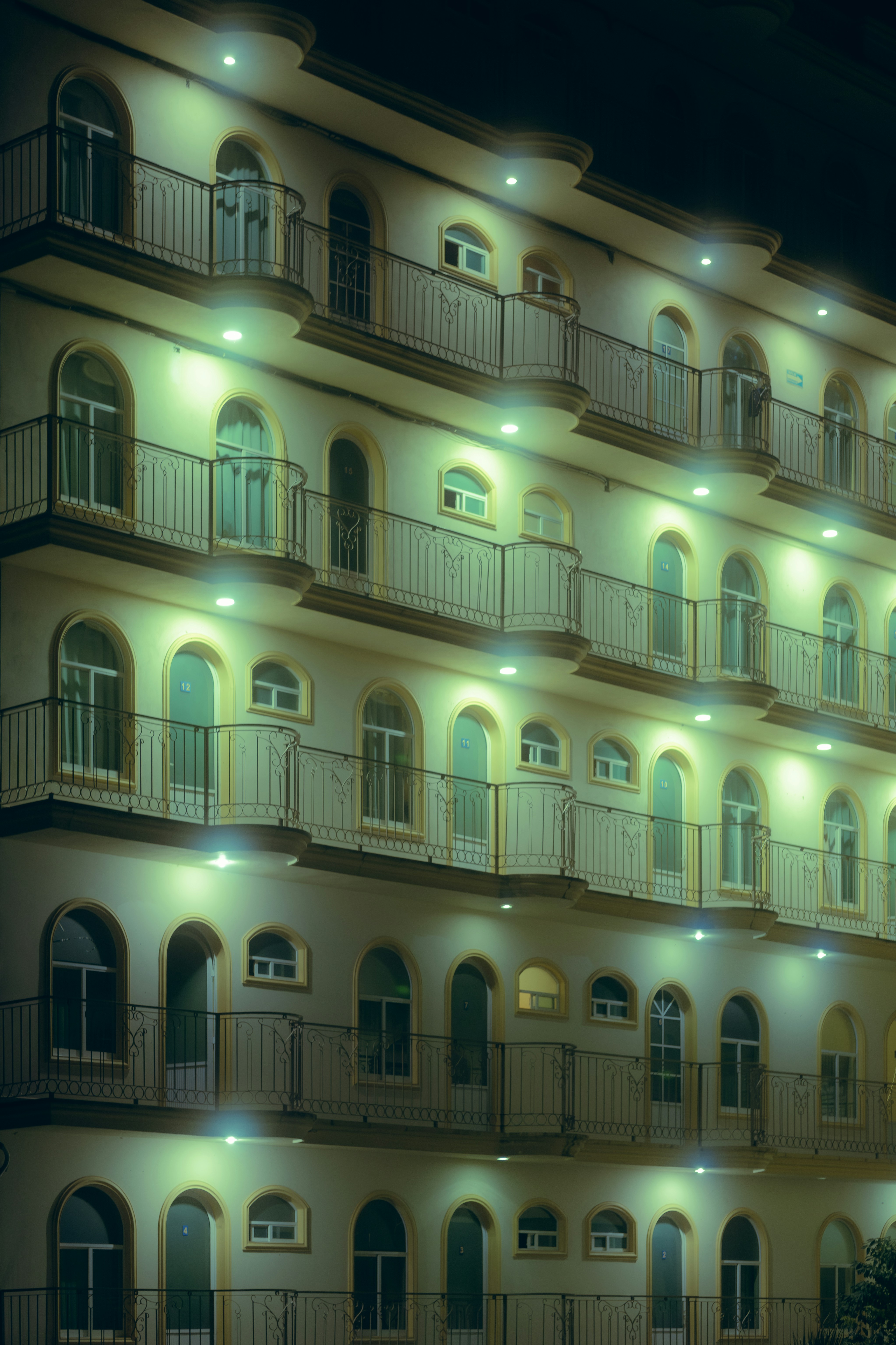 Building with balconies glows brightly at night. photo – Free Travel ...