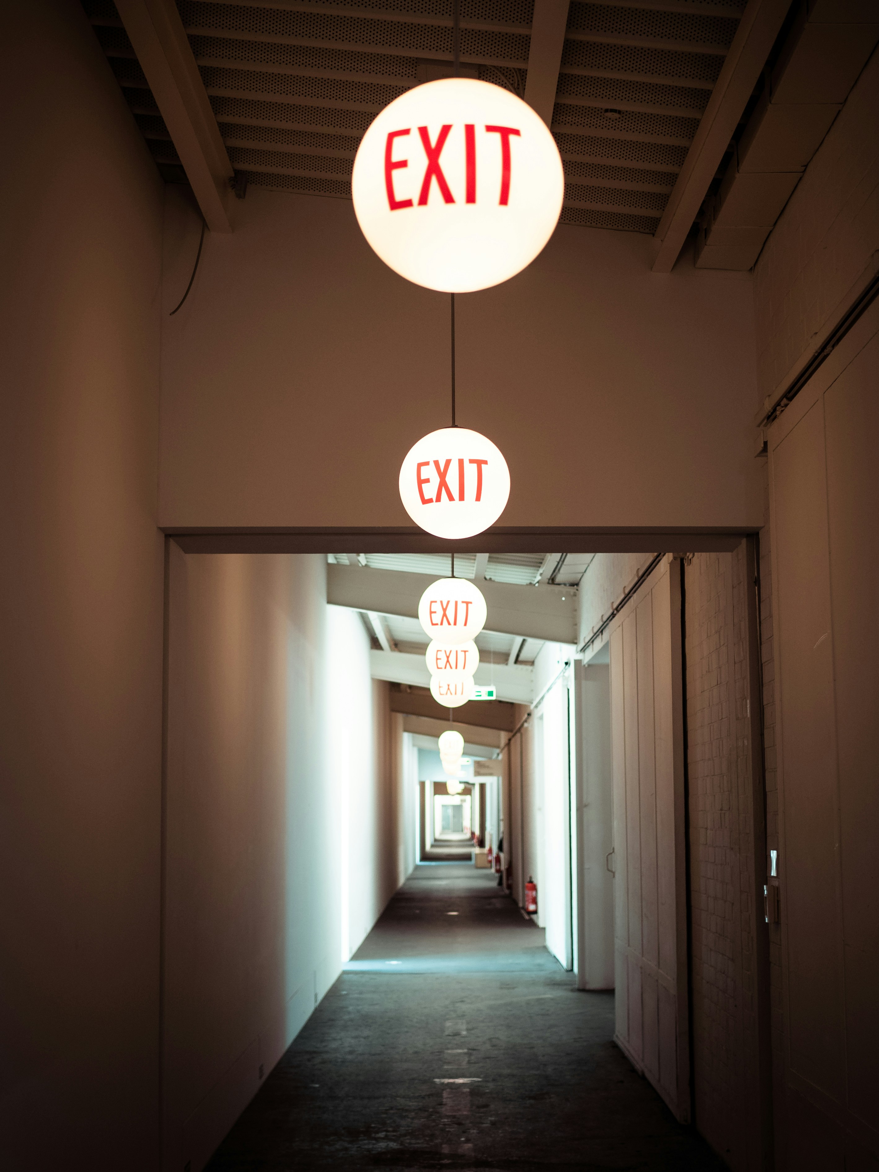Hallway with exit signs guiding the way. photo – Free Exit Image on ...