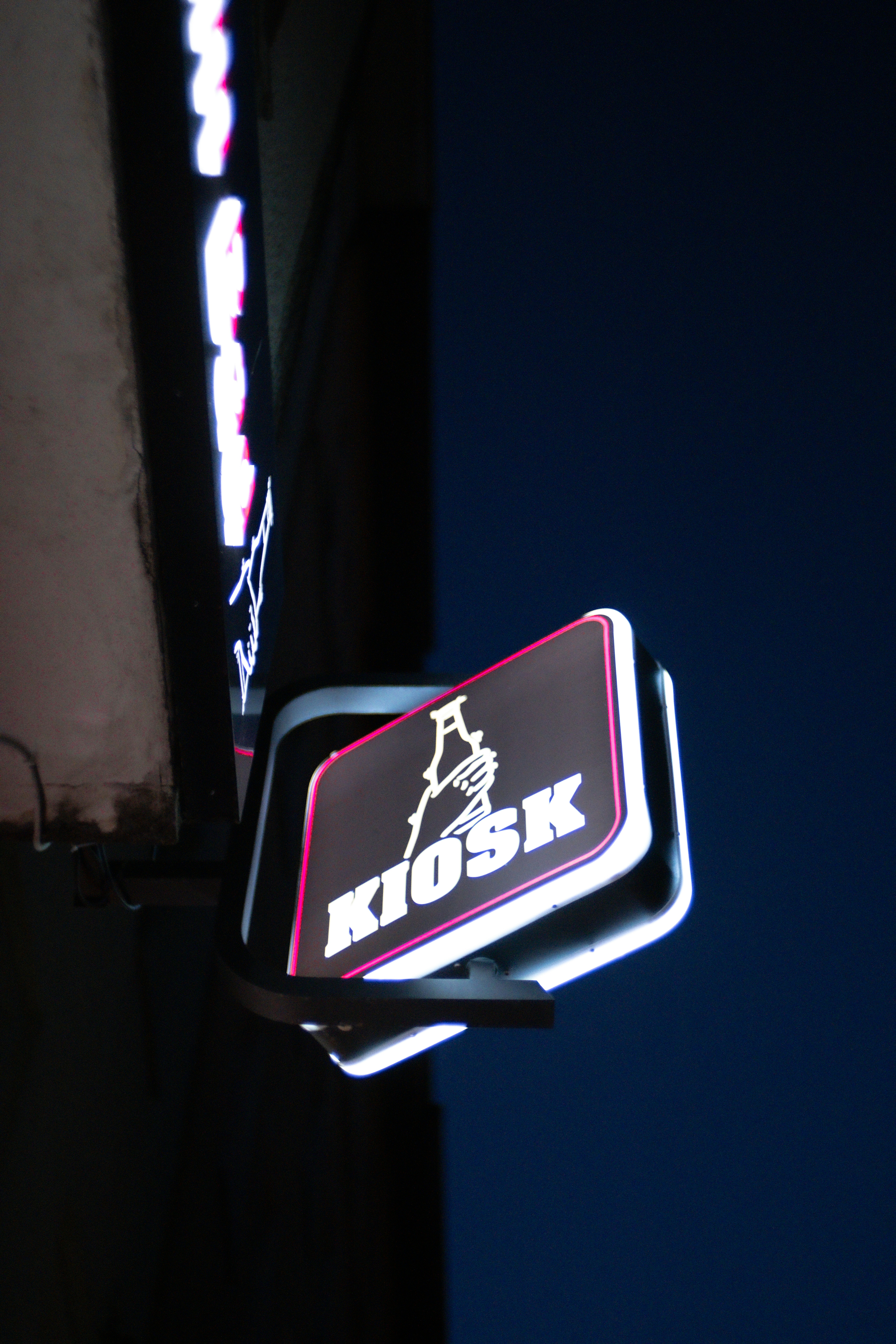 A glowing kiosk sign shines brightly at night. photo – Free Night Image ...