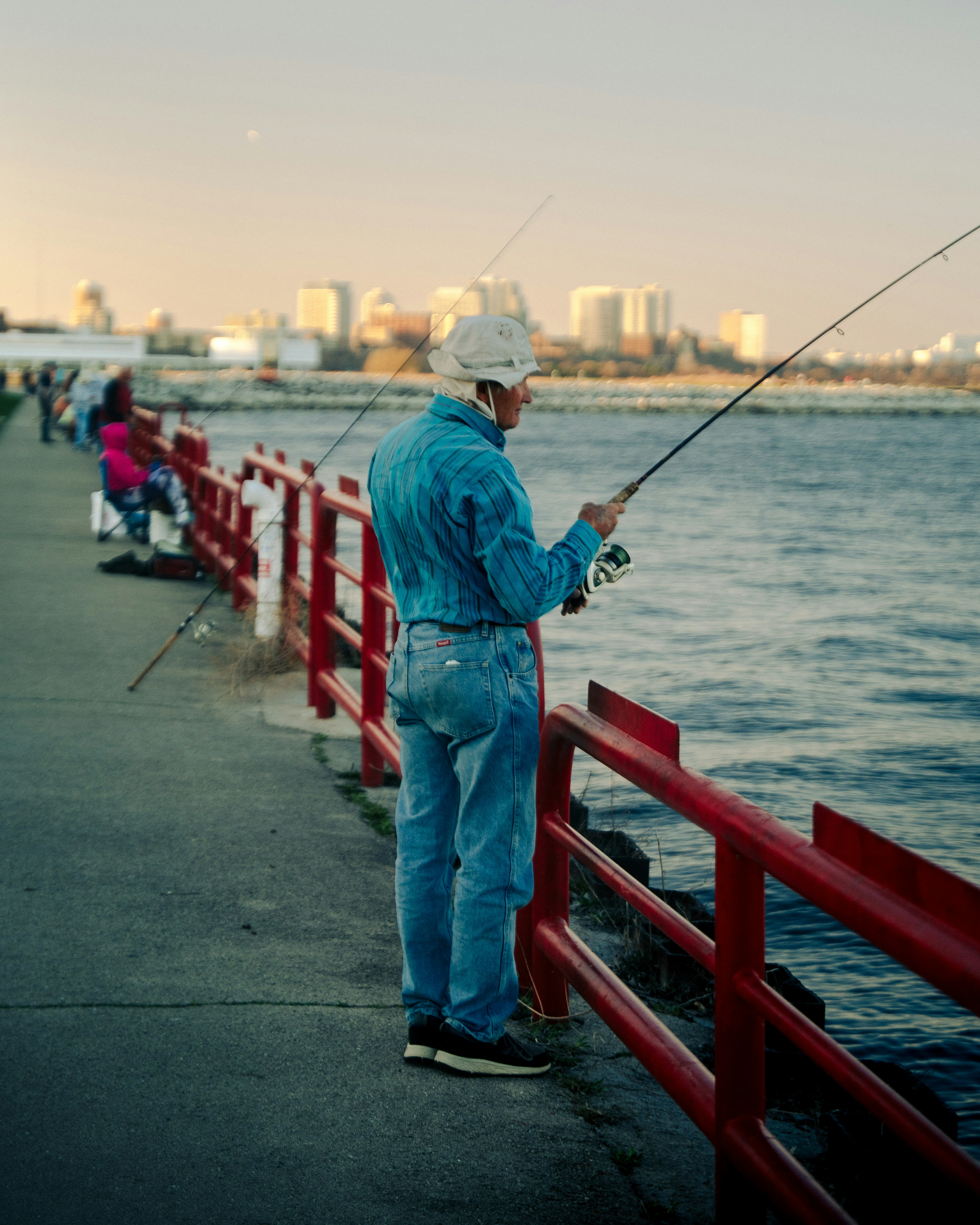 Lines of Light: A Fisherman in Quiet Focus Along the Waterfront