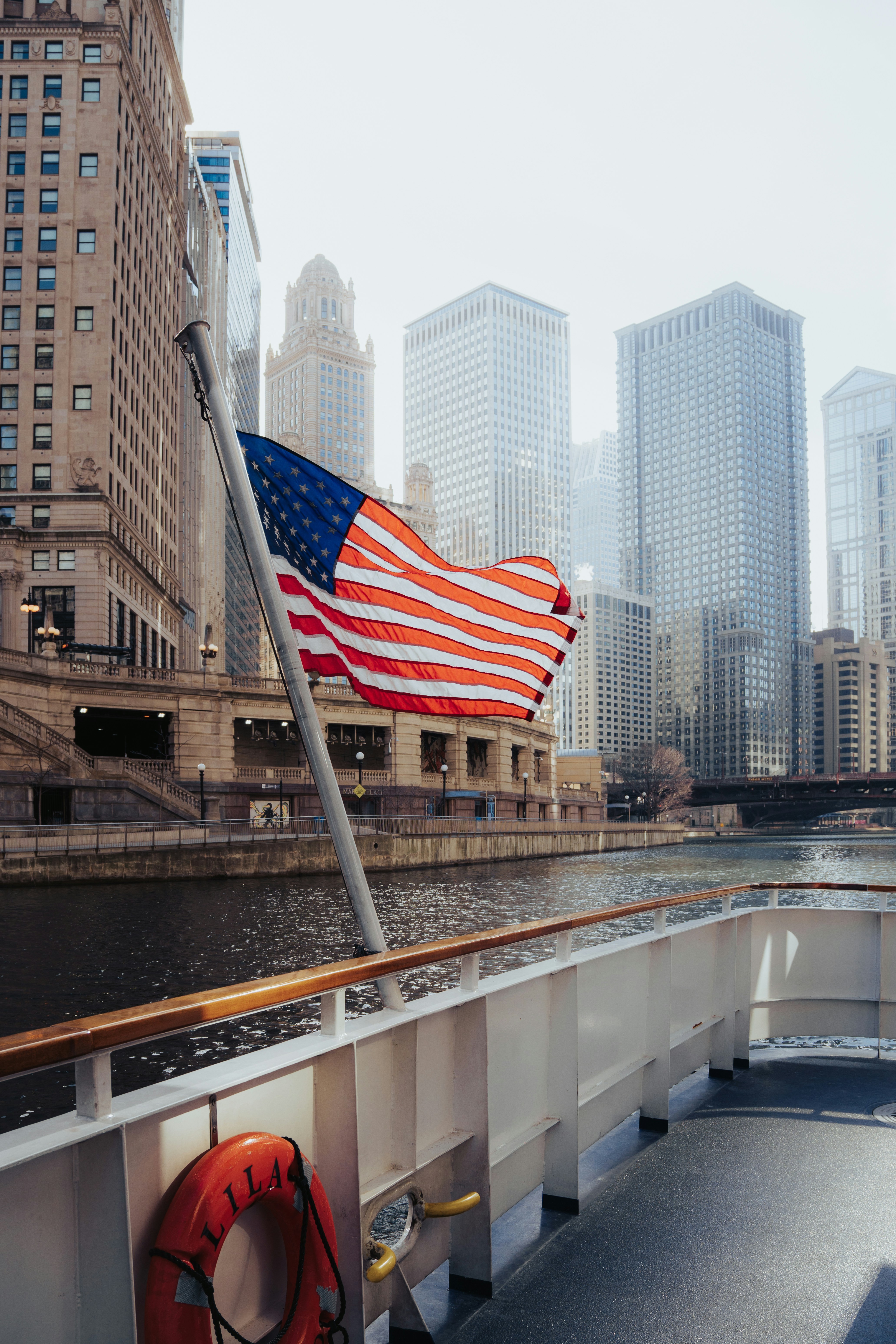 Flag Over the Waterline: Wind-Tugged Emblem Against a Steel City Skyline