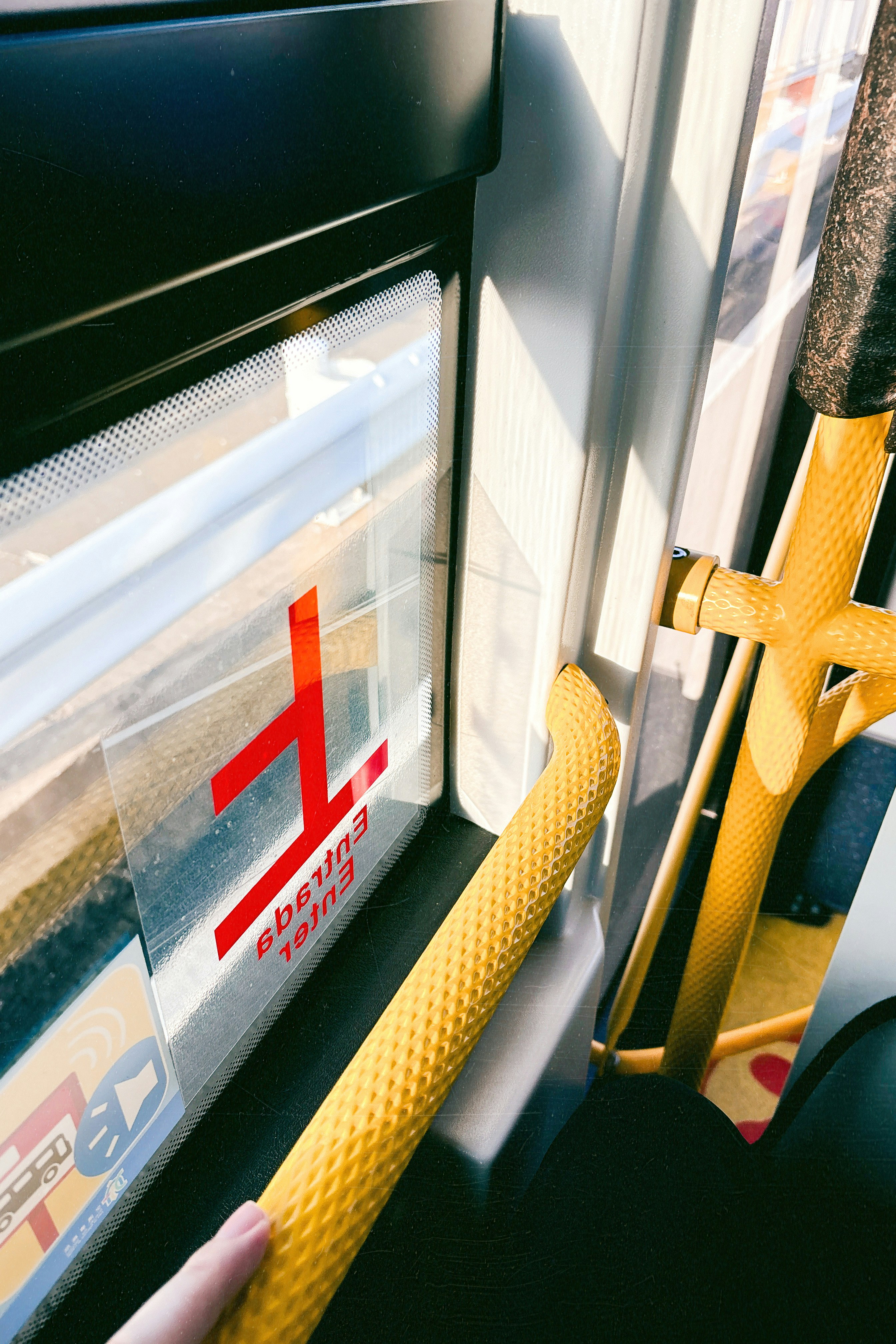 Glowing Transit Grip: A Close-Up of a Bright Yellow Handrail by the Window