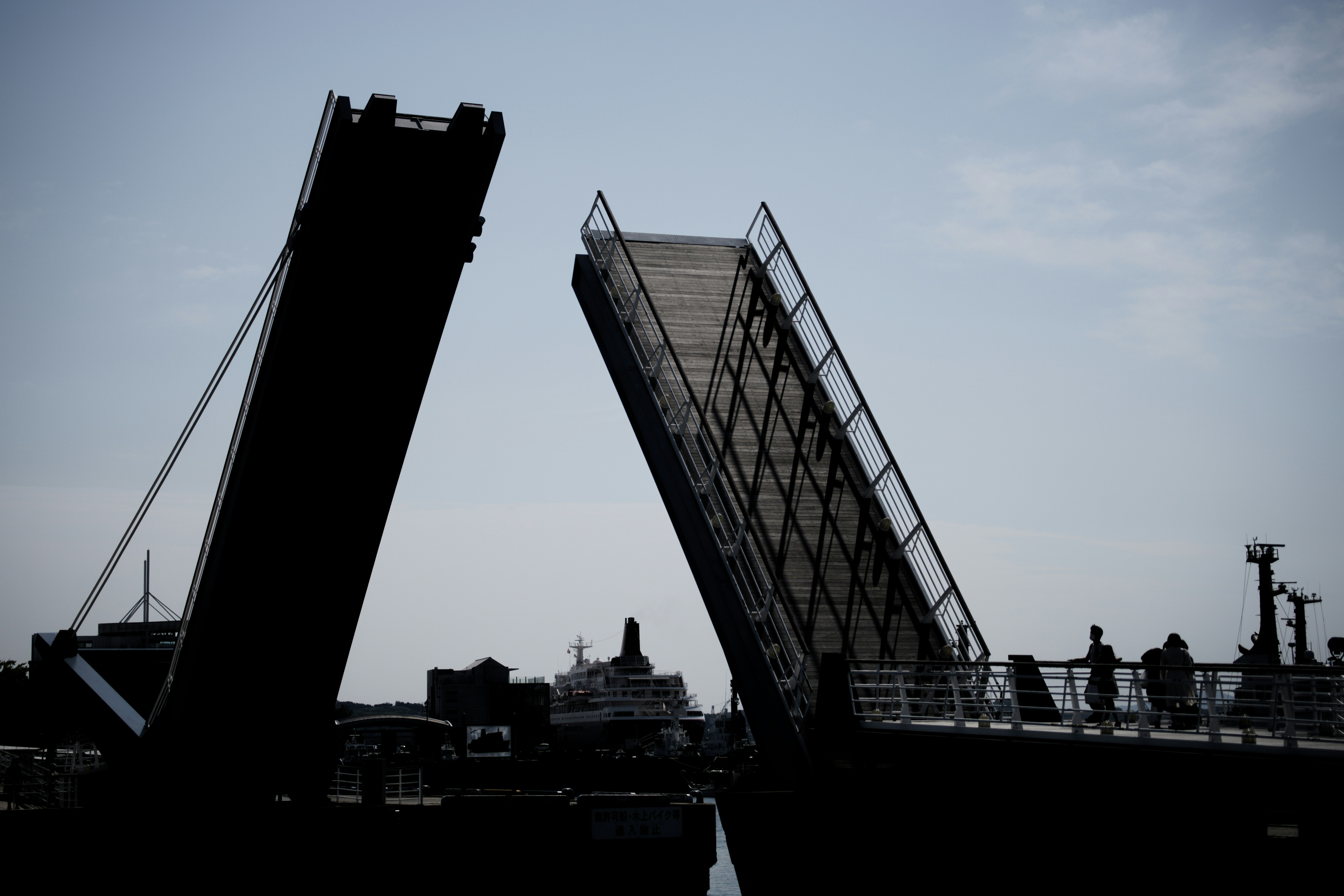 Rising Bridge Gates at Dusk: A Silent Maritime Crossing