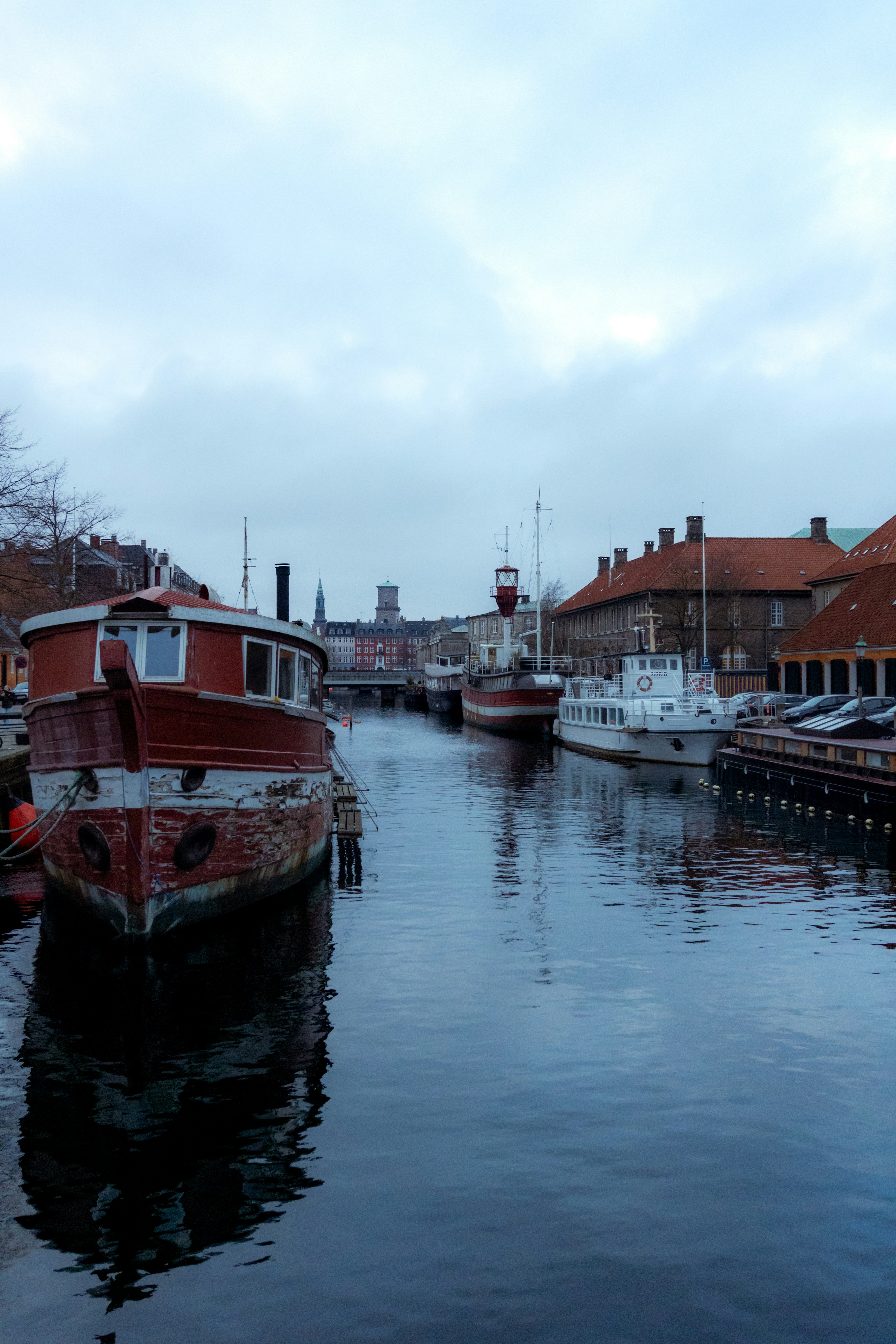 Red-hulled boats at a calm Dutch canal