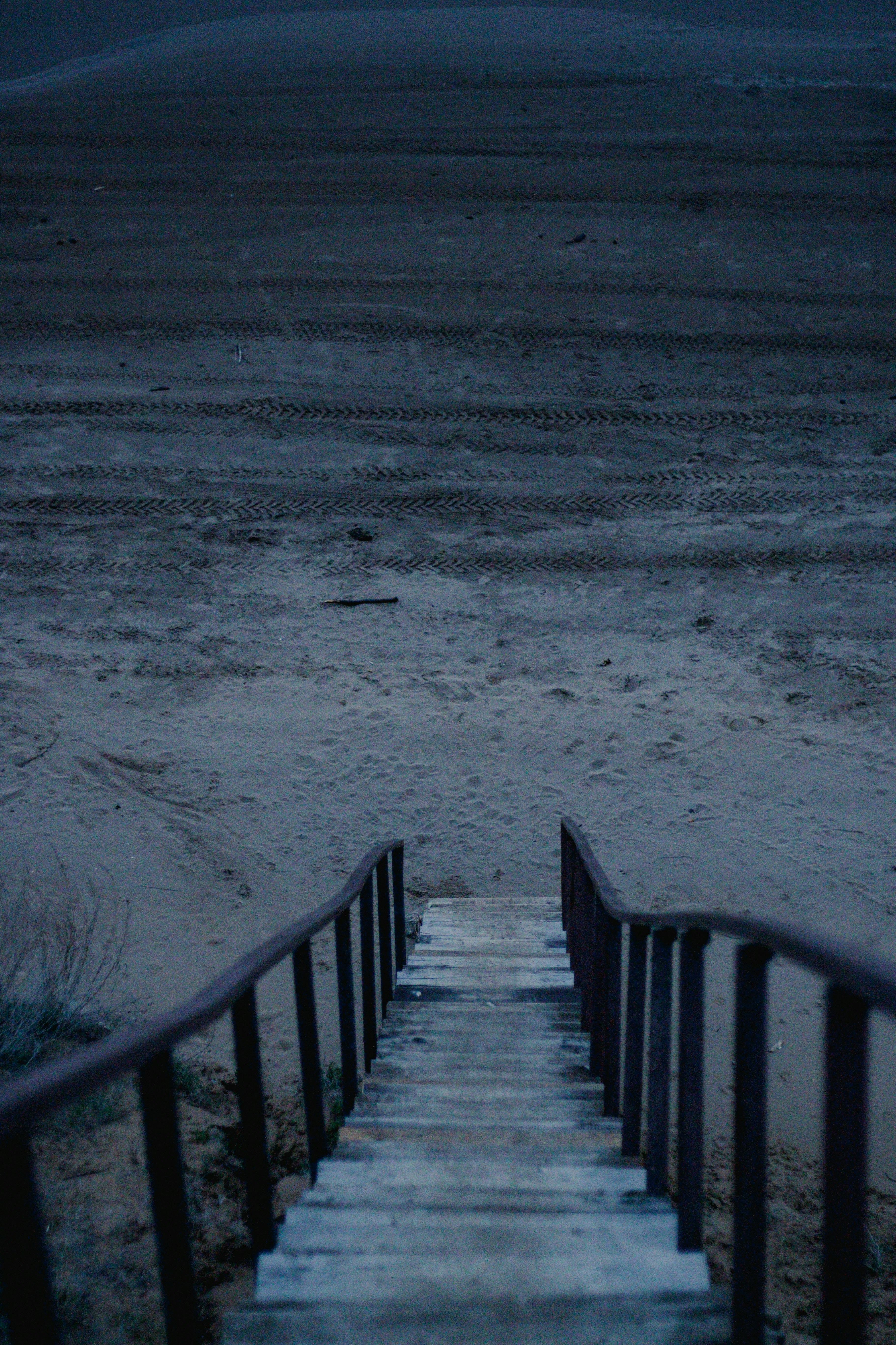 Stairs lead down to a sandy, desolate landscape.