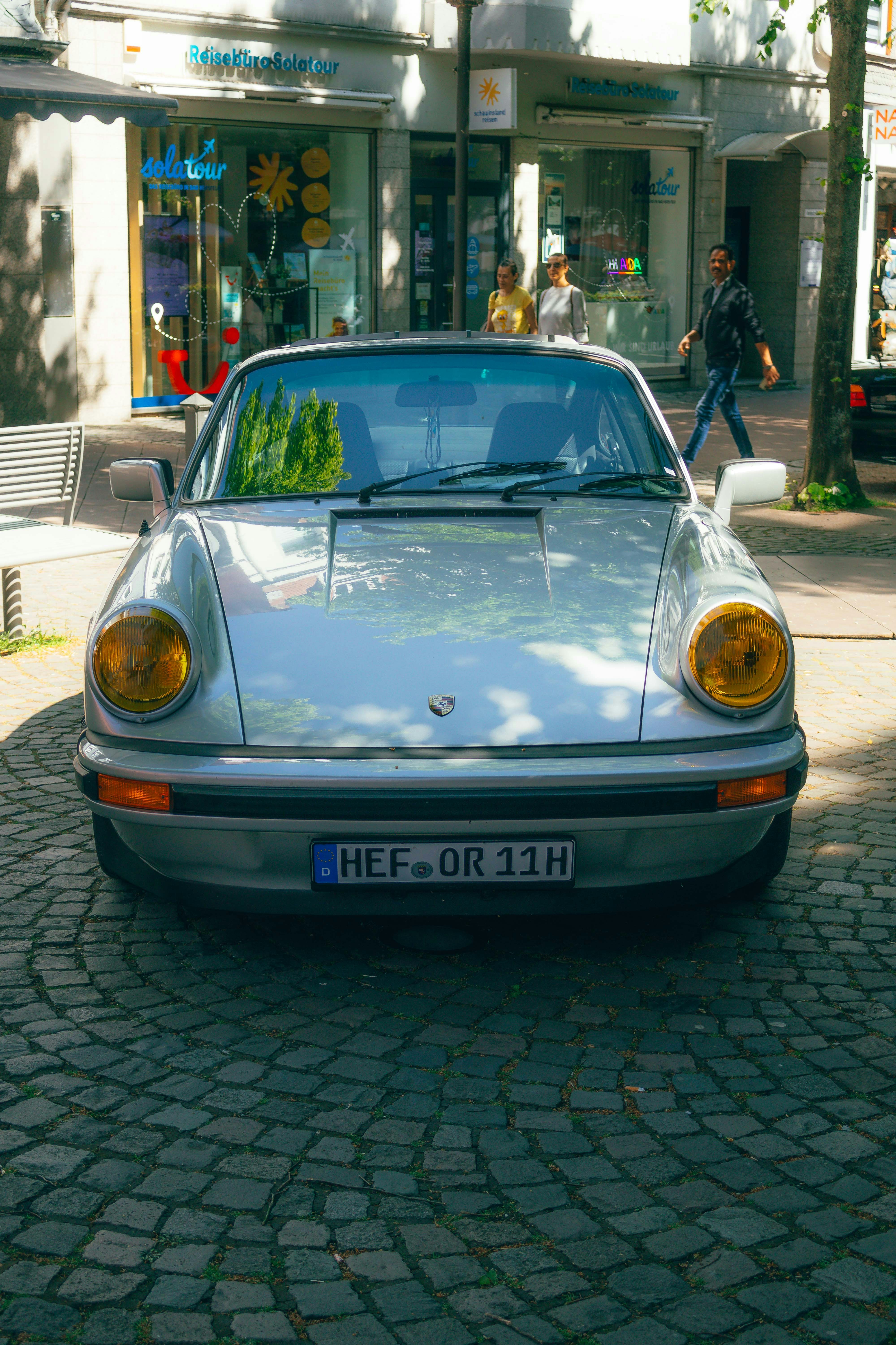 Front View of a Classic Porsche 911 on a Sunlit Cobblestone Street