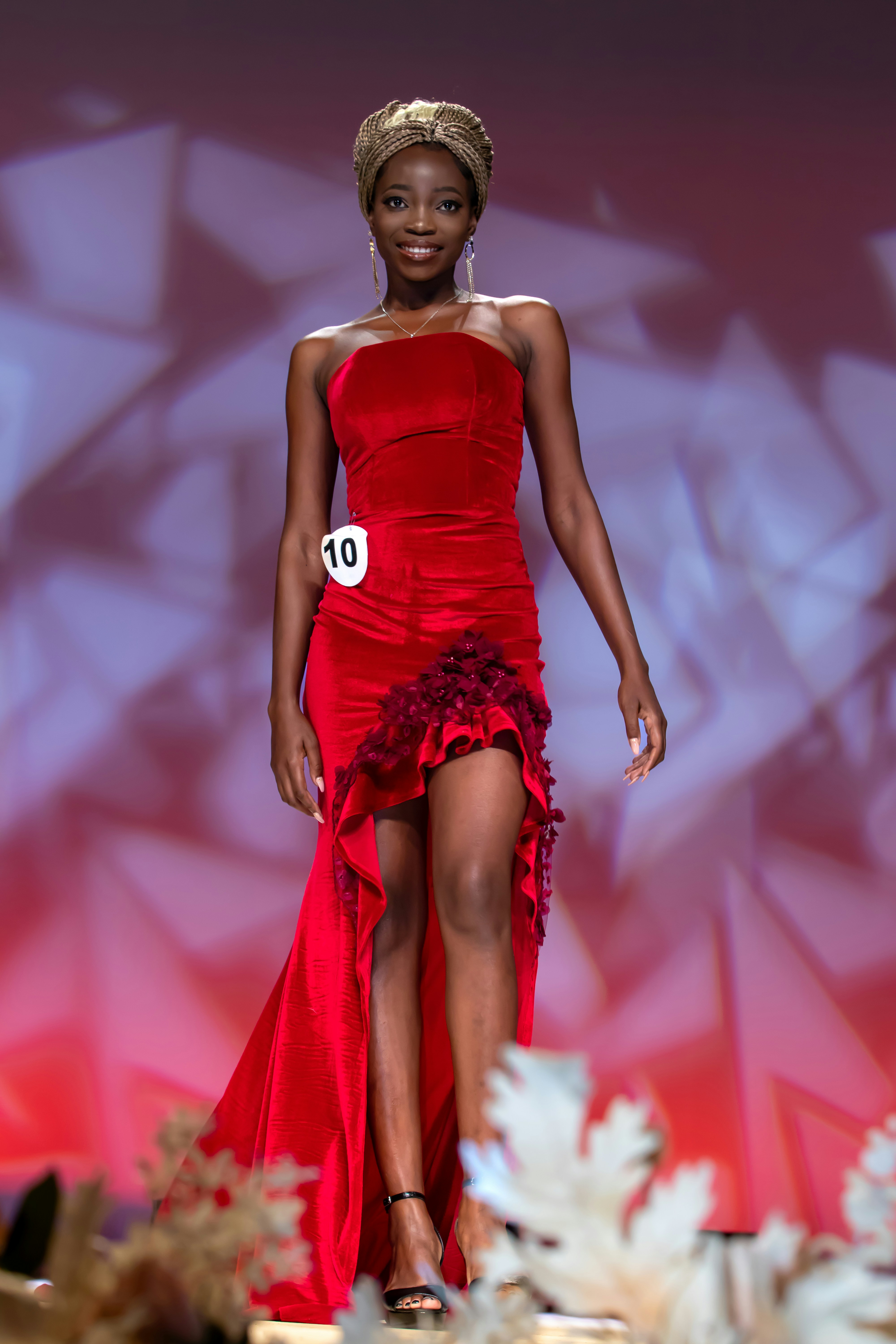 A woman struts down a runway in a red gown. photo – Free Fashion Image ...