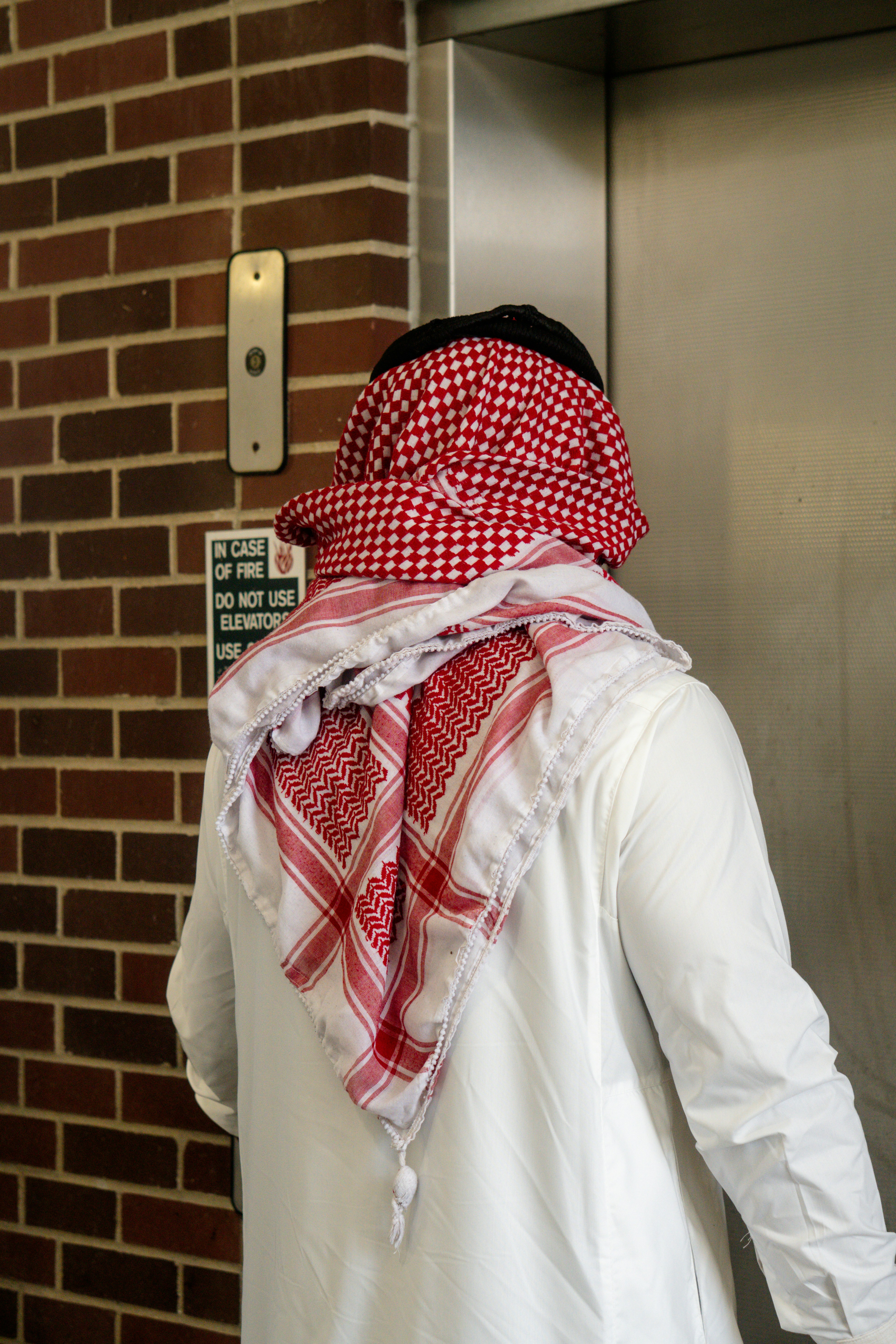 A man in traditional clothing enters an elevator. photo – Free Man ...
