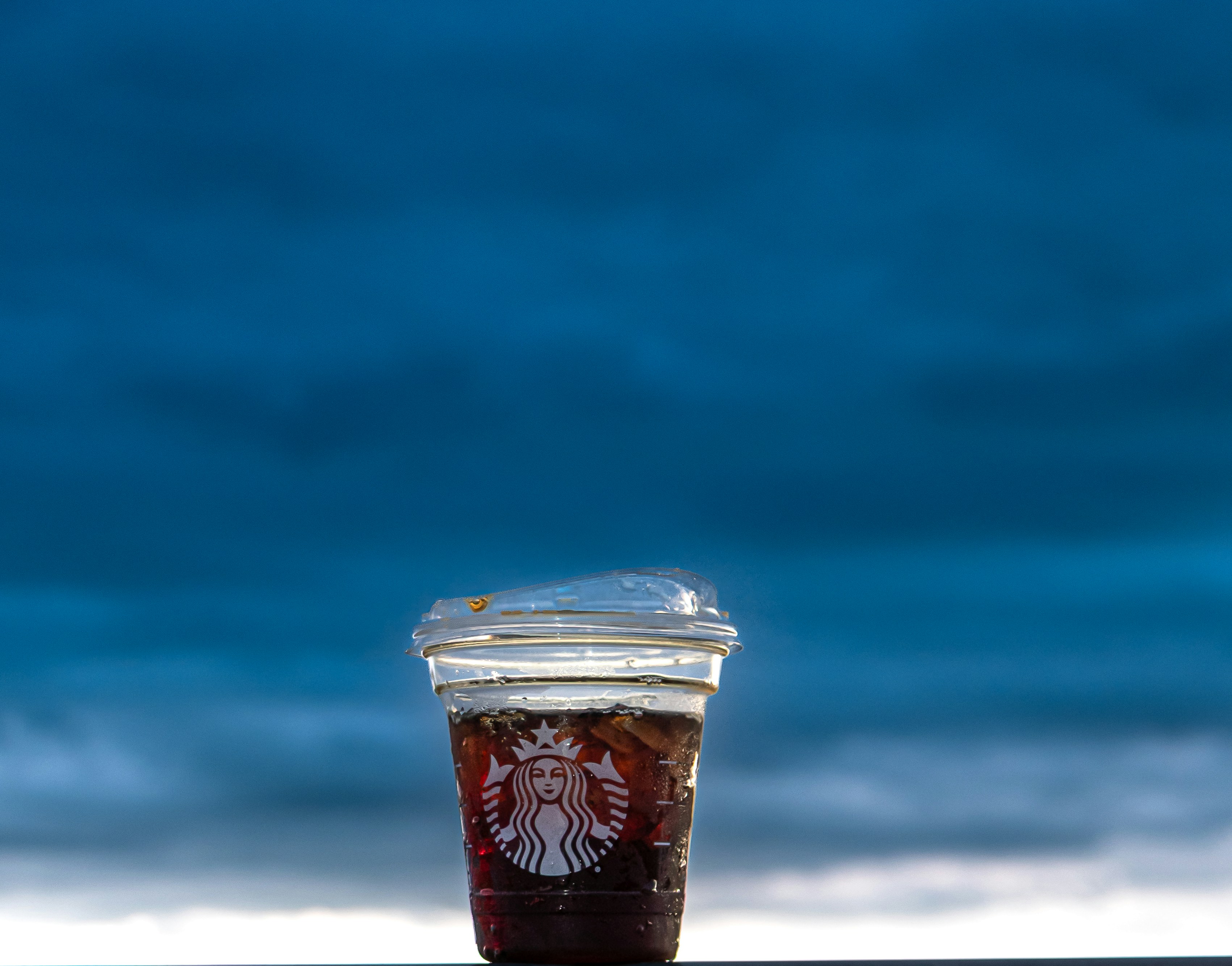 Liquid Snow: A Starbucks Cup Quietly Protrudes from the Horizon