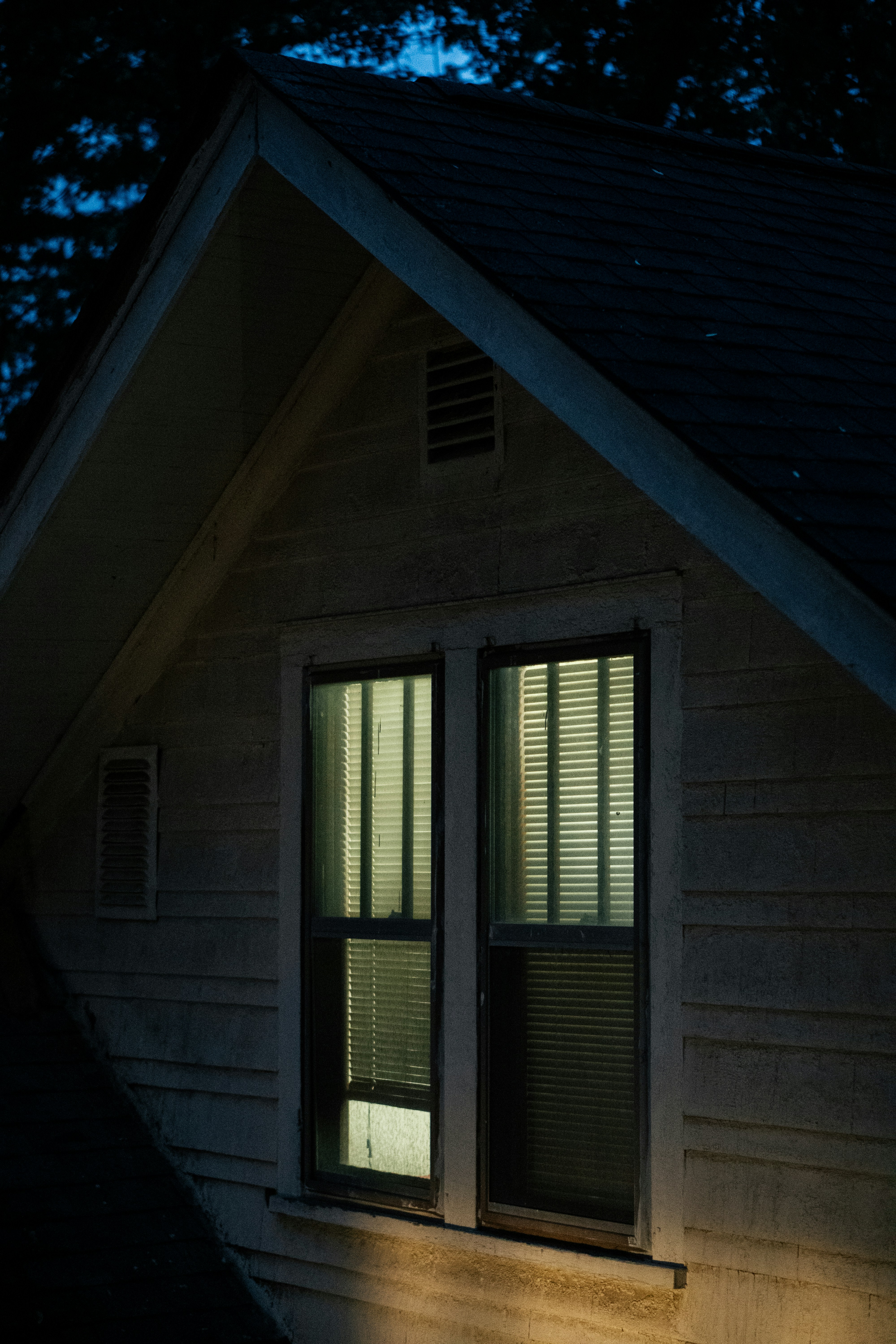 midwestern emo roof | Attic window lit up at night.