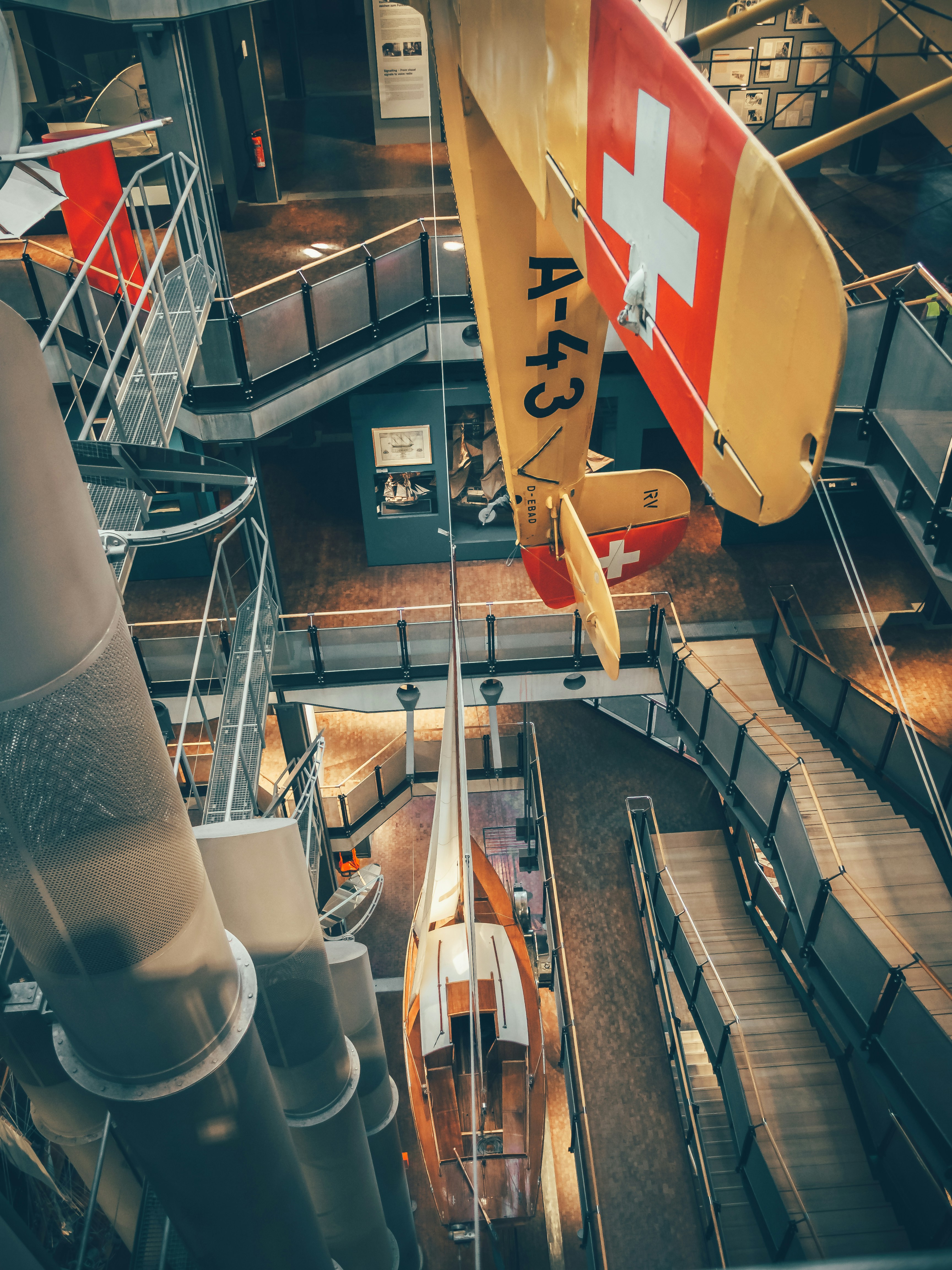 Inside a museum, planes and boats are displayed.