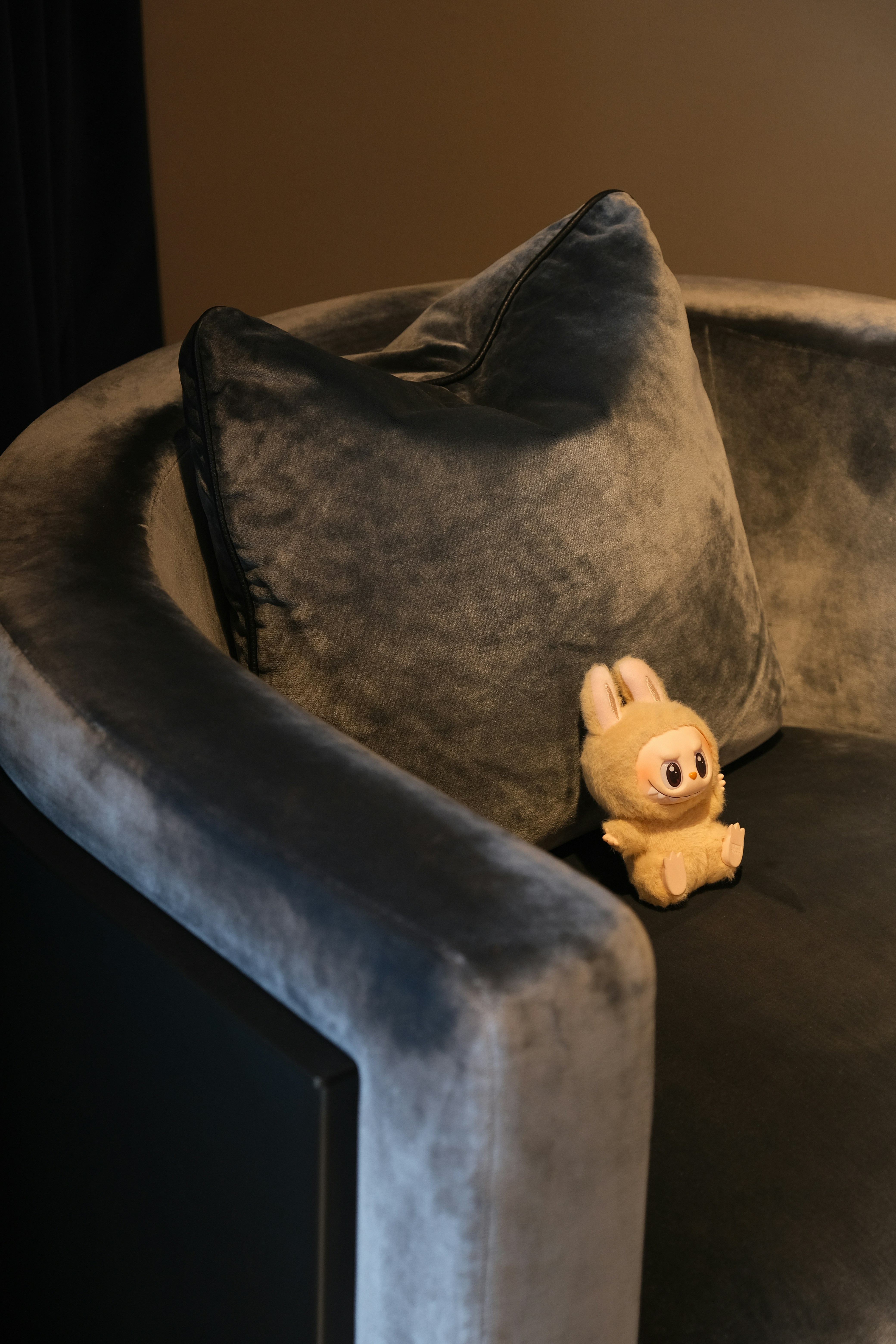 A stuffed bunny sits on a comfortable couch. photo – Free Labubu Image ...