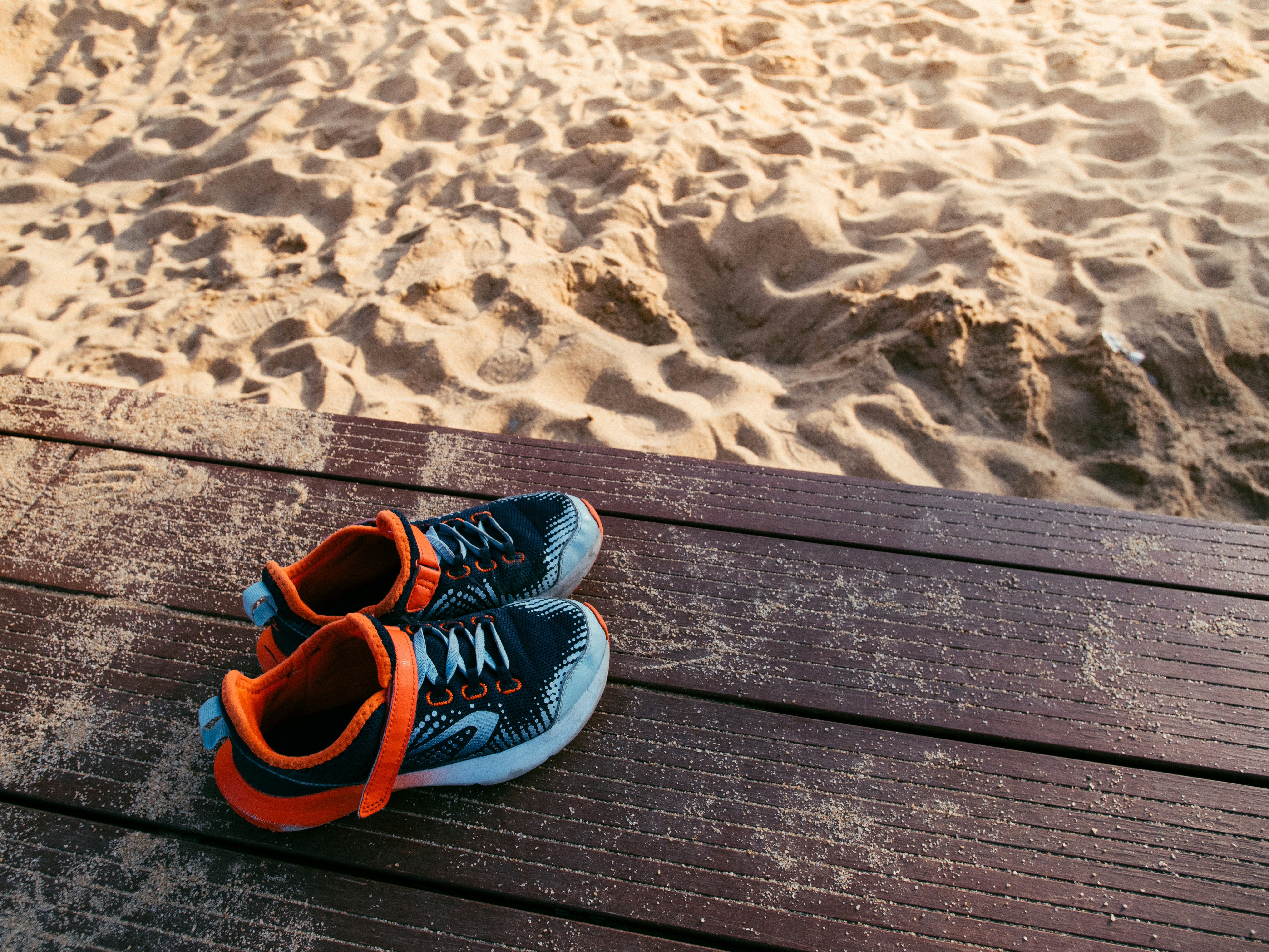 Blue Sneakers on a Weathered Deck: A Quiet Beach Moment