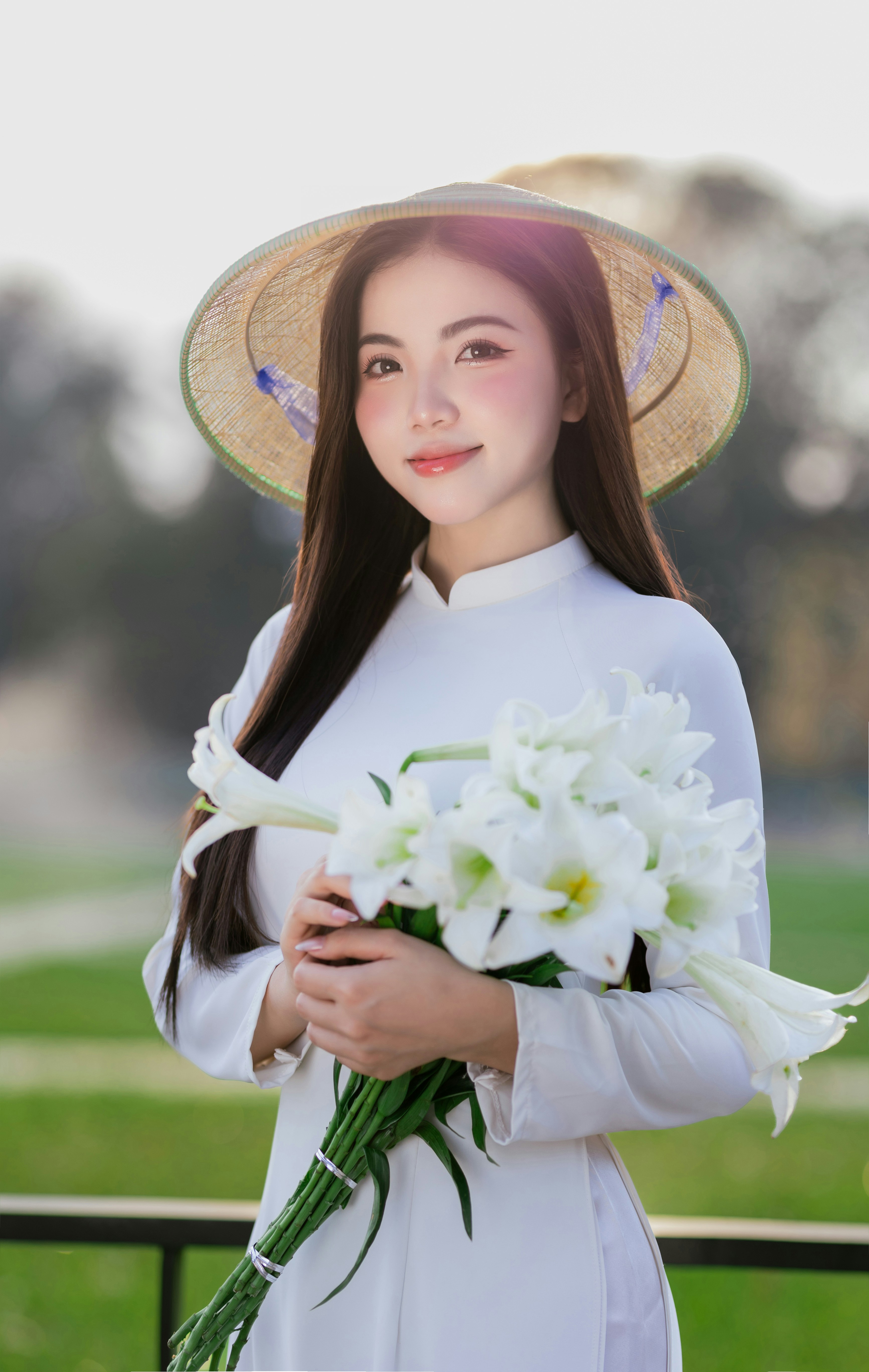 A woman smiles holding lilies, wearing a traditional outfit. photo ...