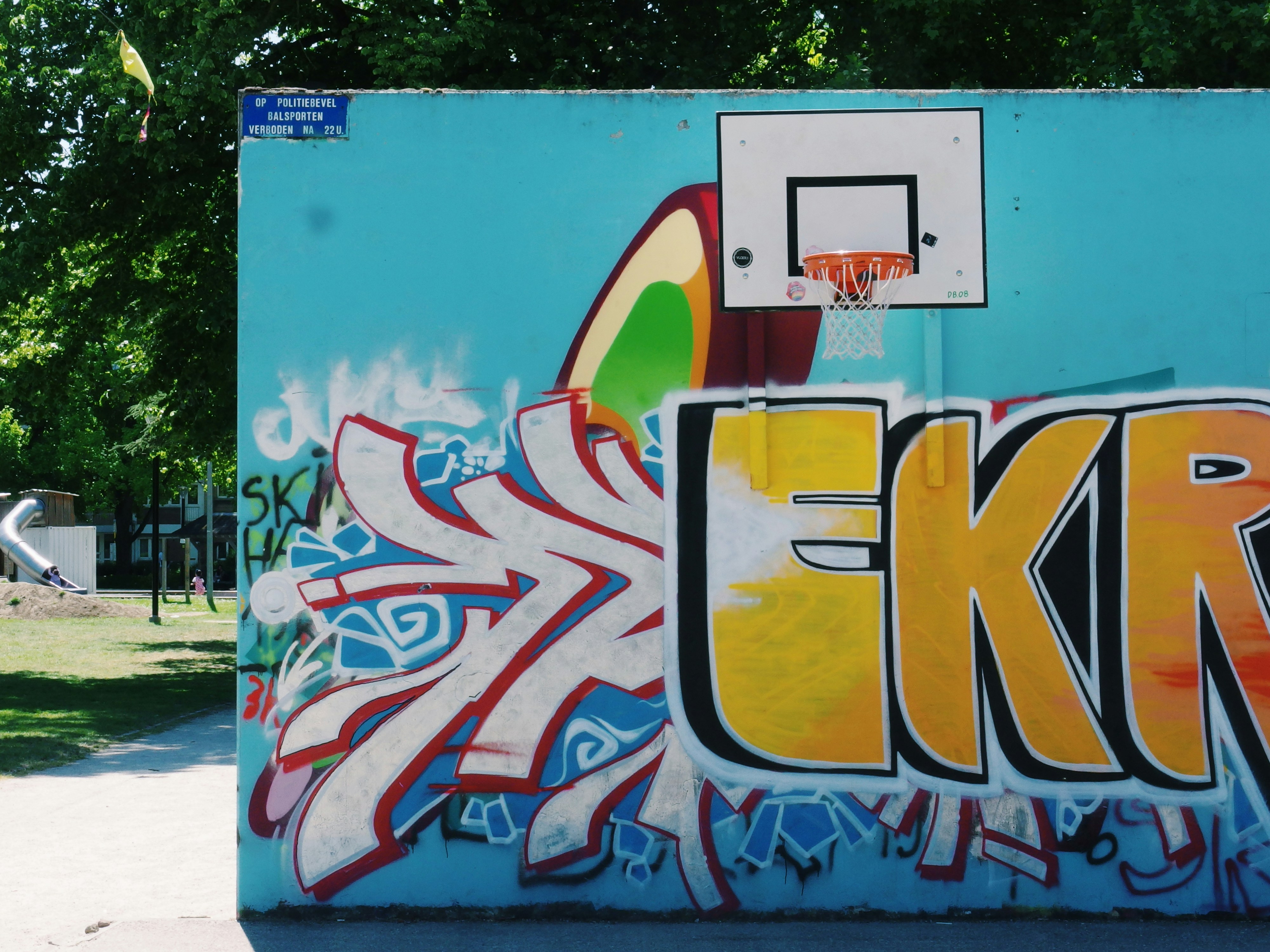 Graffiti art adorns a basketball hoop.