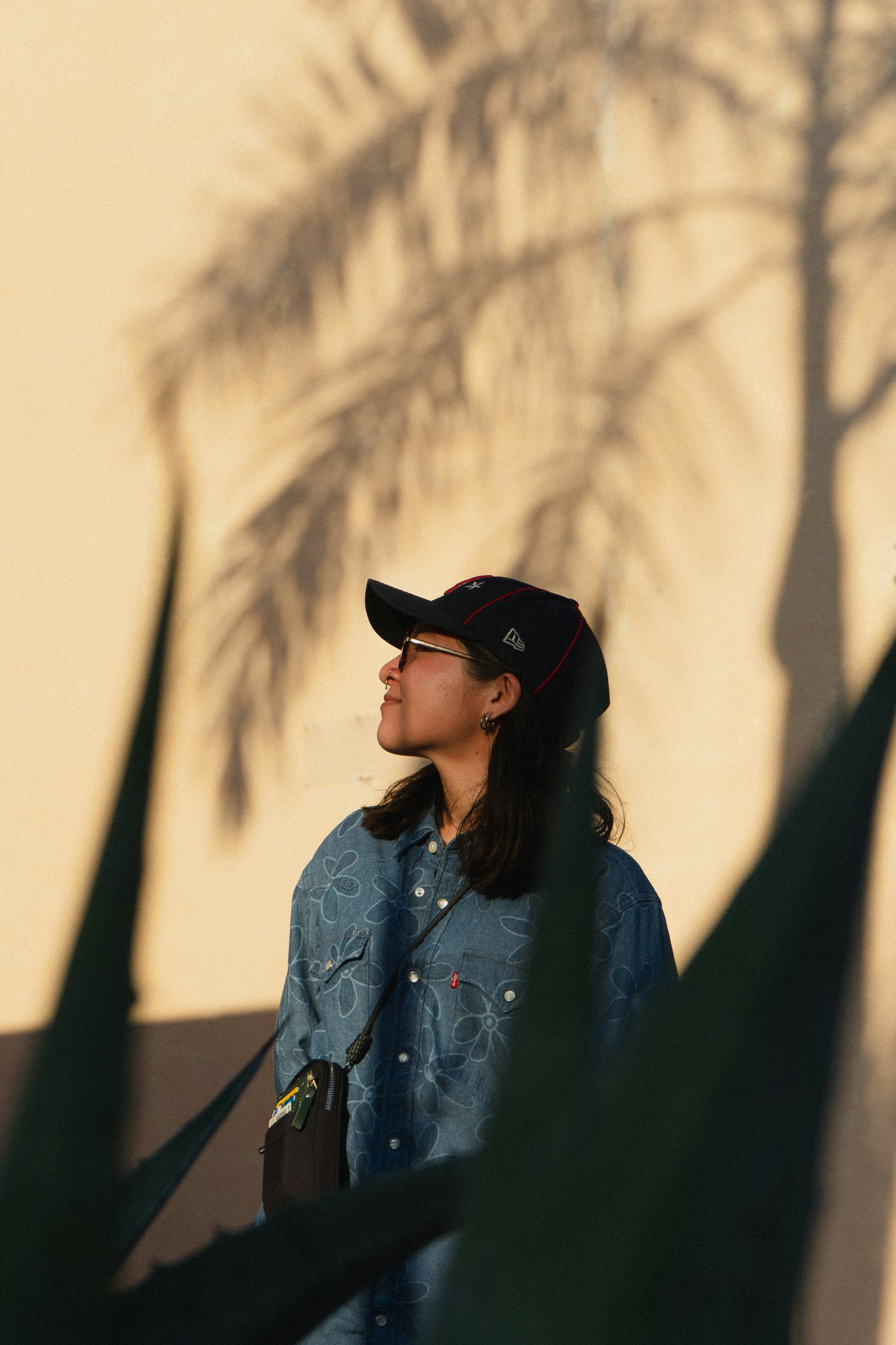 Cap, Denim, and Palm Shadows: A Quiet Portrait in Golden Light