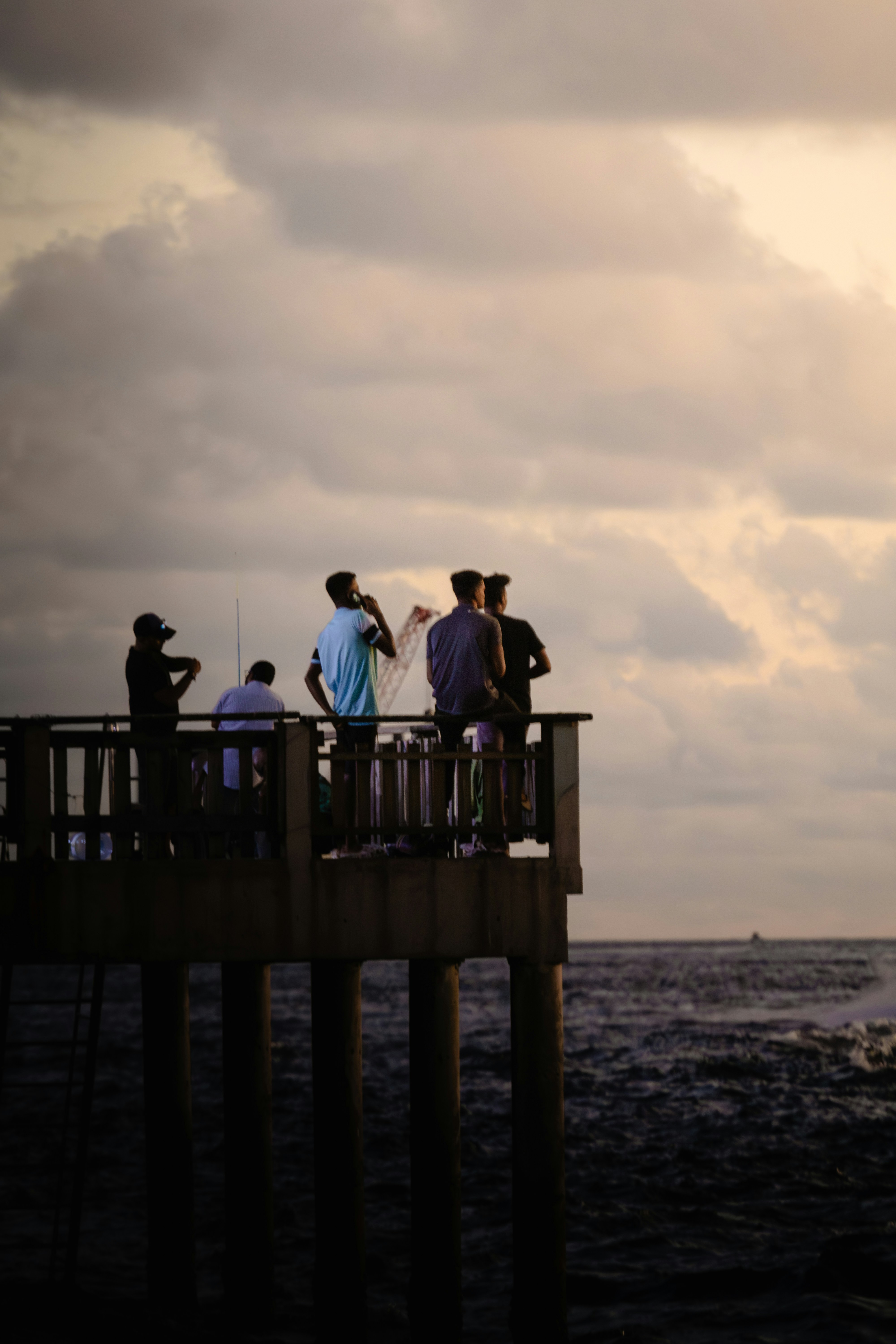 Dusk on the Pier: Five Figures Cast in Gentle Ocean Light