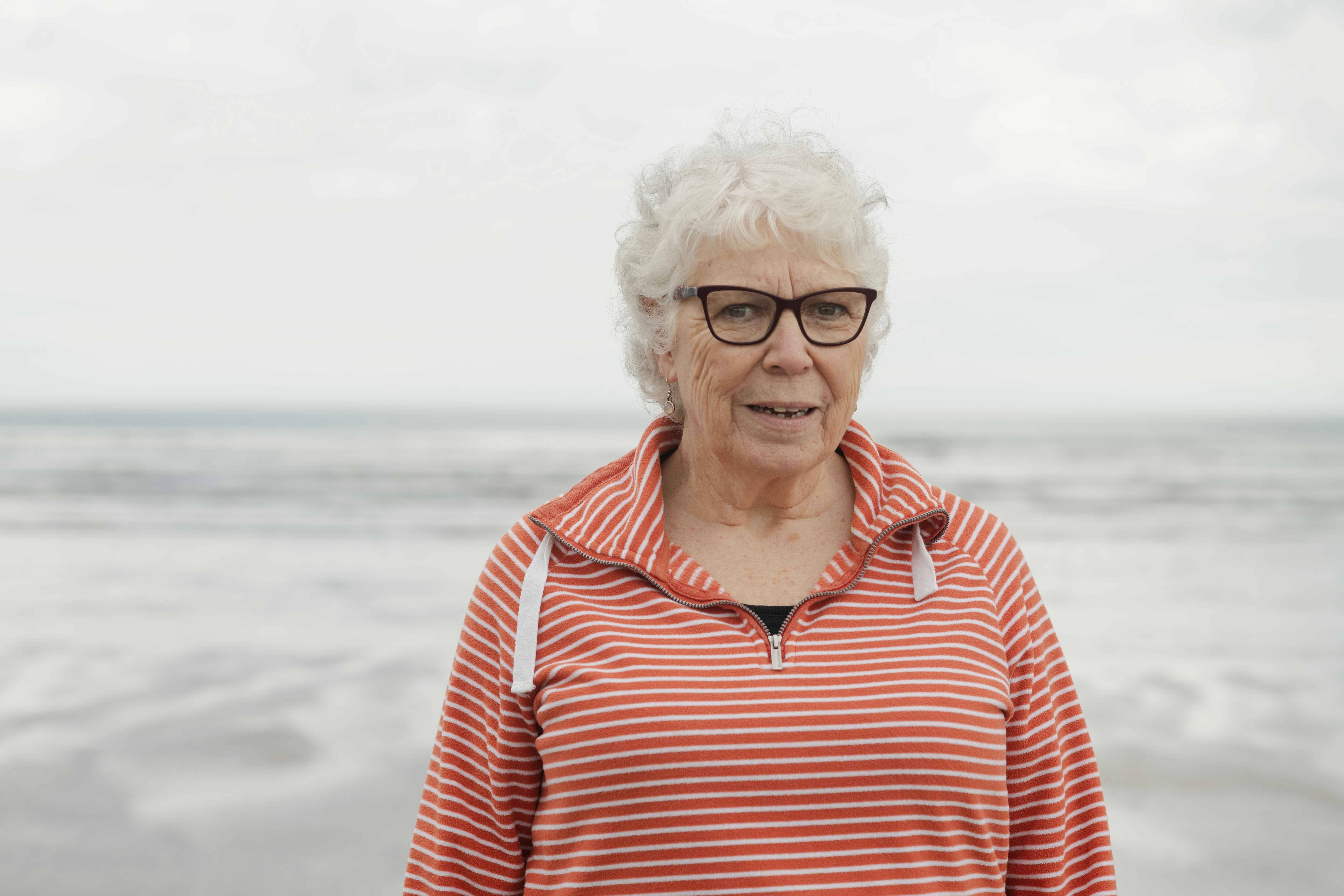 Red Stripes and Sea Light: A Quiet Portrait on the Shore