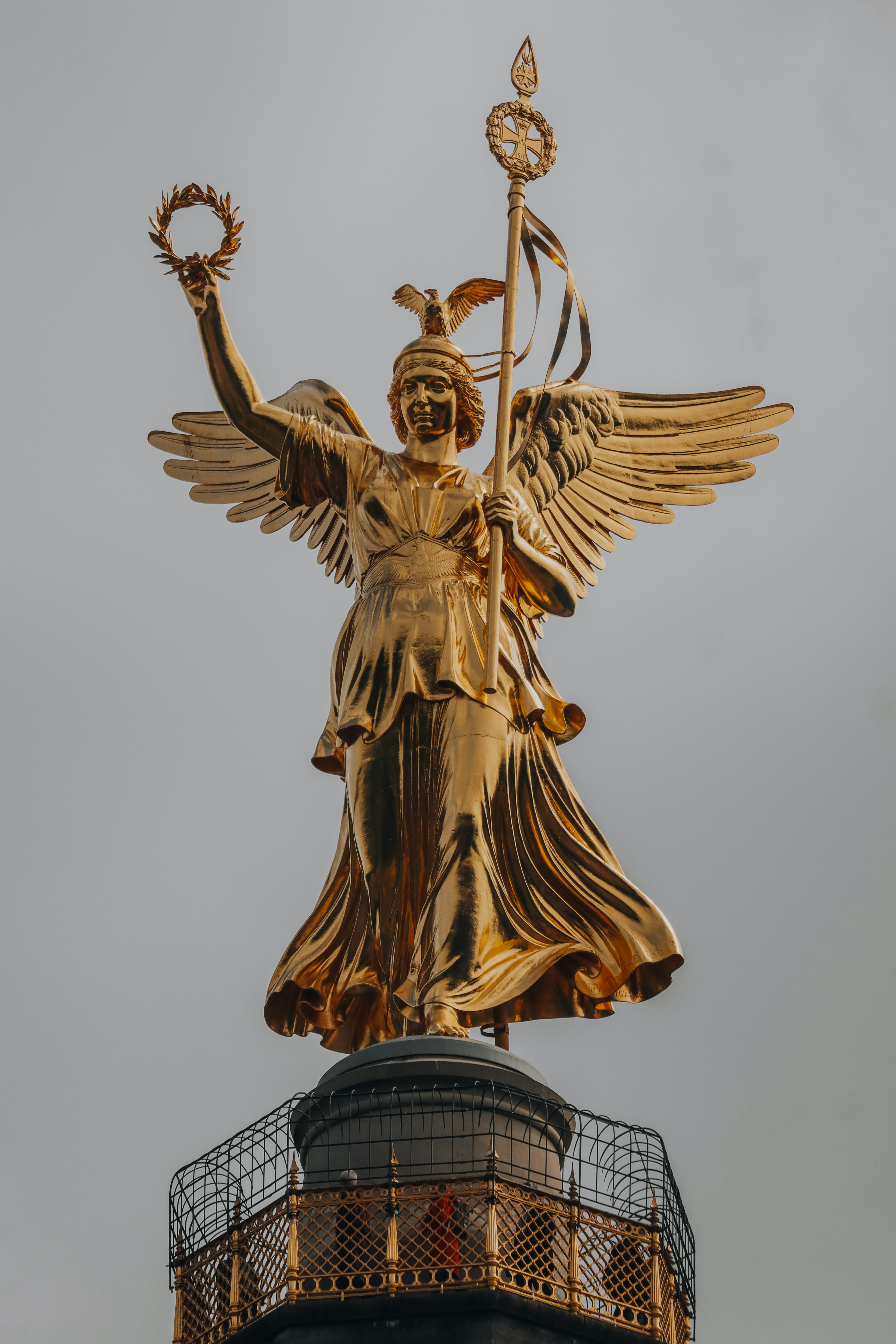 Golden Winged Victory Surges Above a Latticed Turret