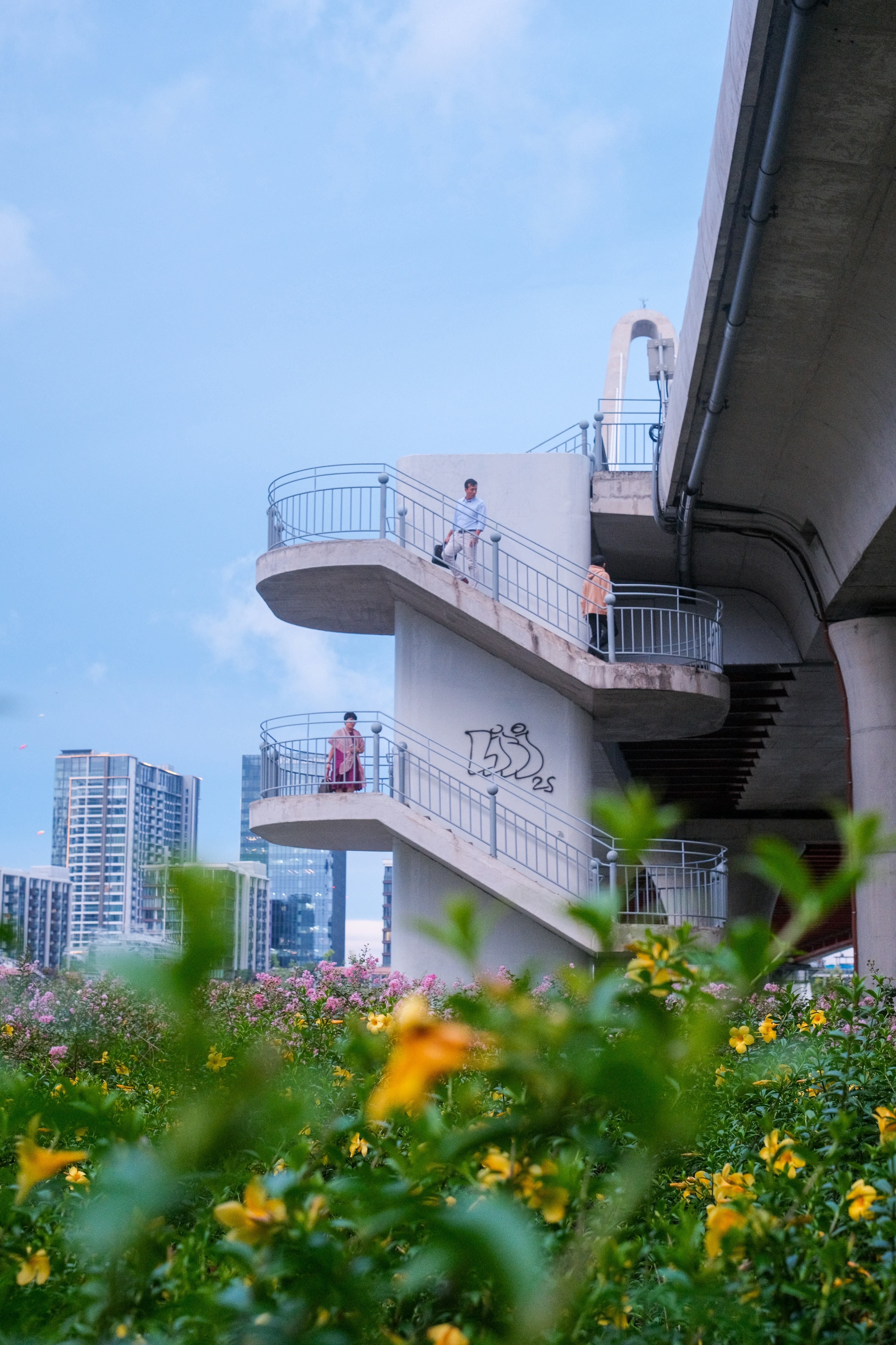 Concrete Helix Above the City, Framed by Spring Flowers