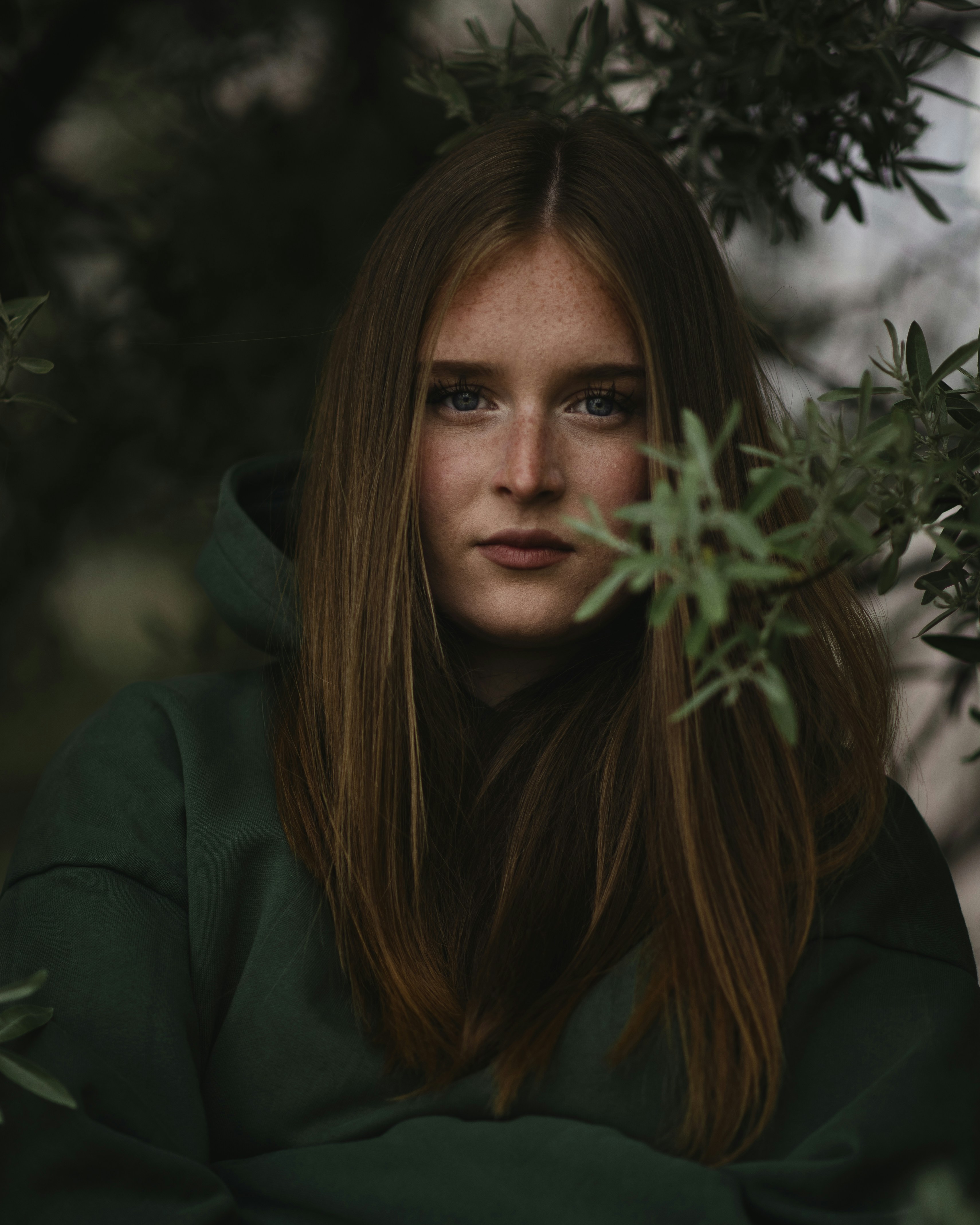 Emerald Veil: A Portrait Framed by Green Foliage