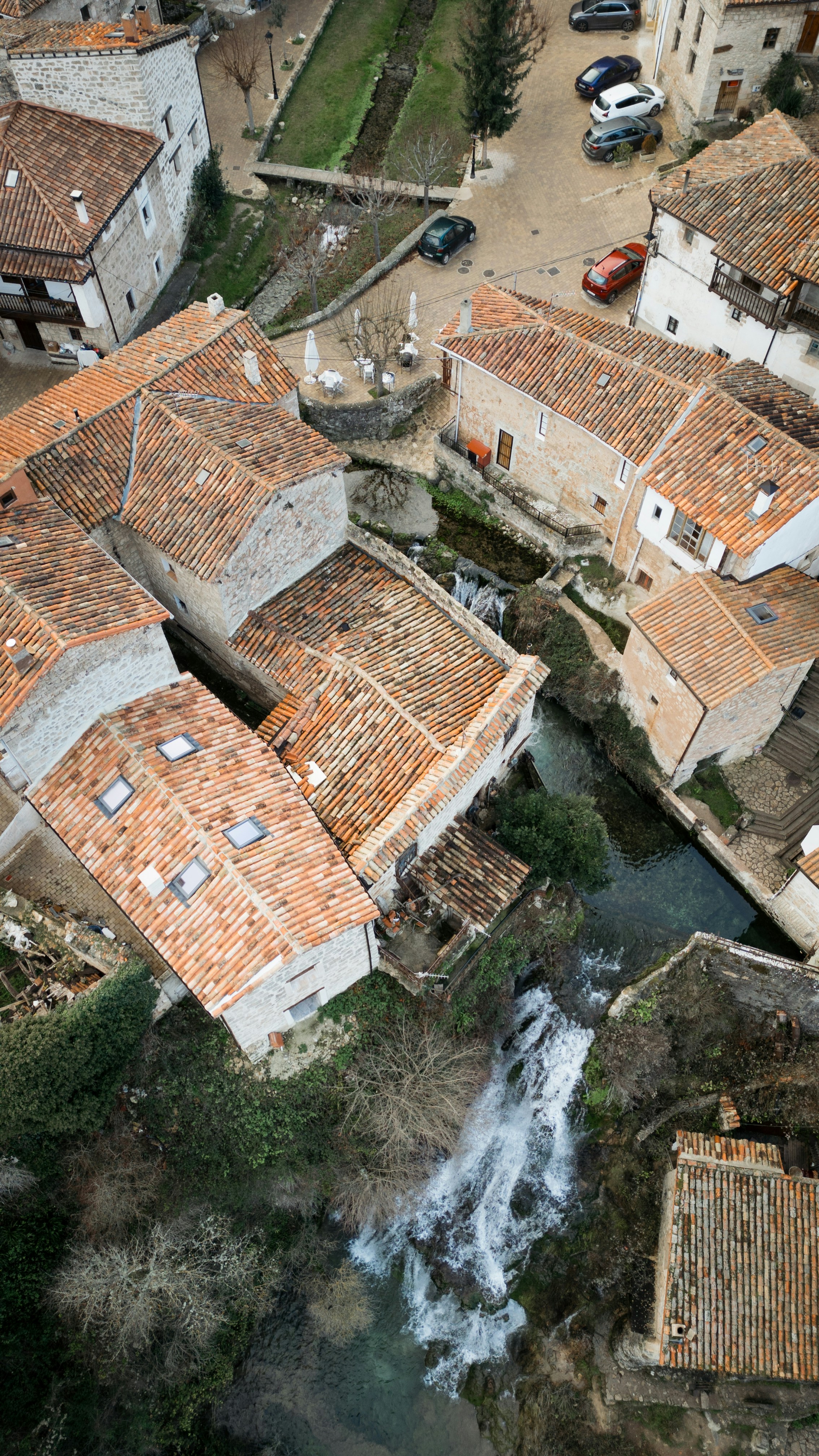 Terracotta Roofscape and Cascading Waterway: Aerial Portrait of a Stone Village