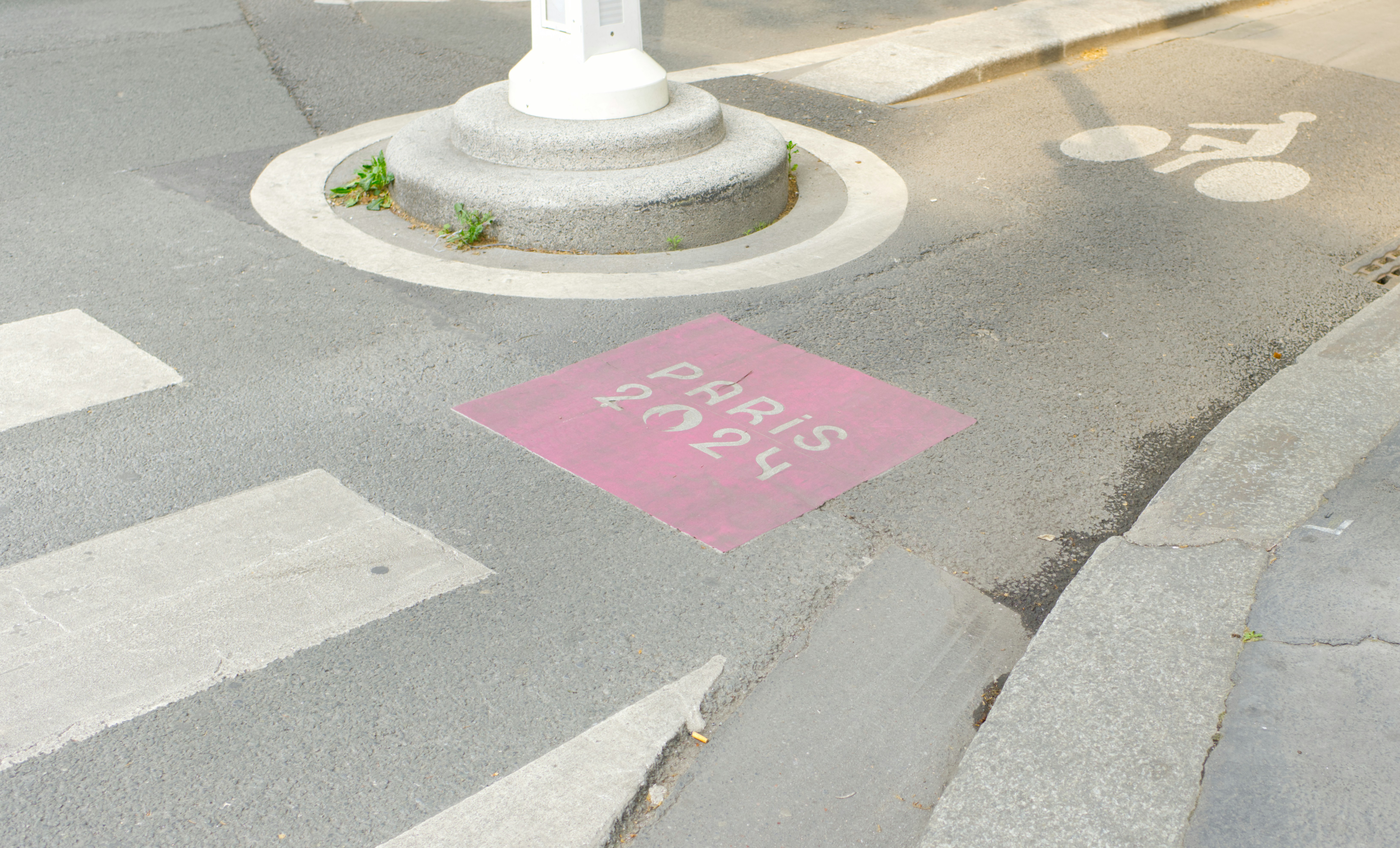 Paris 2016: a pink street-stencil perched along a curb at a city crosswalk
