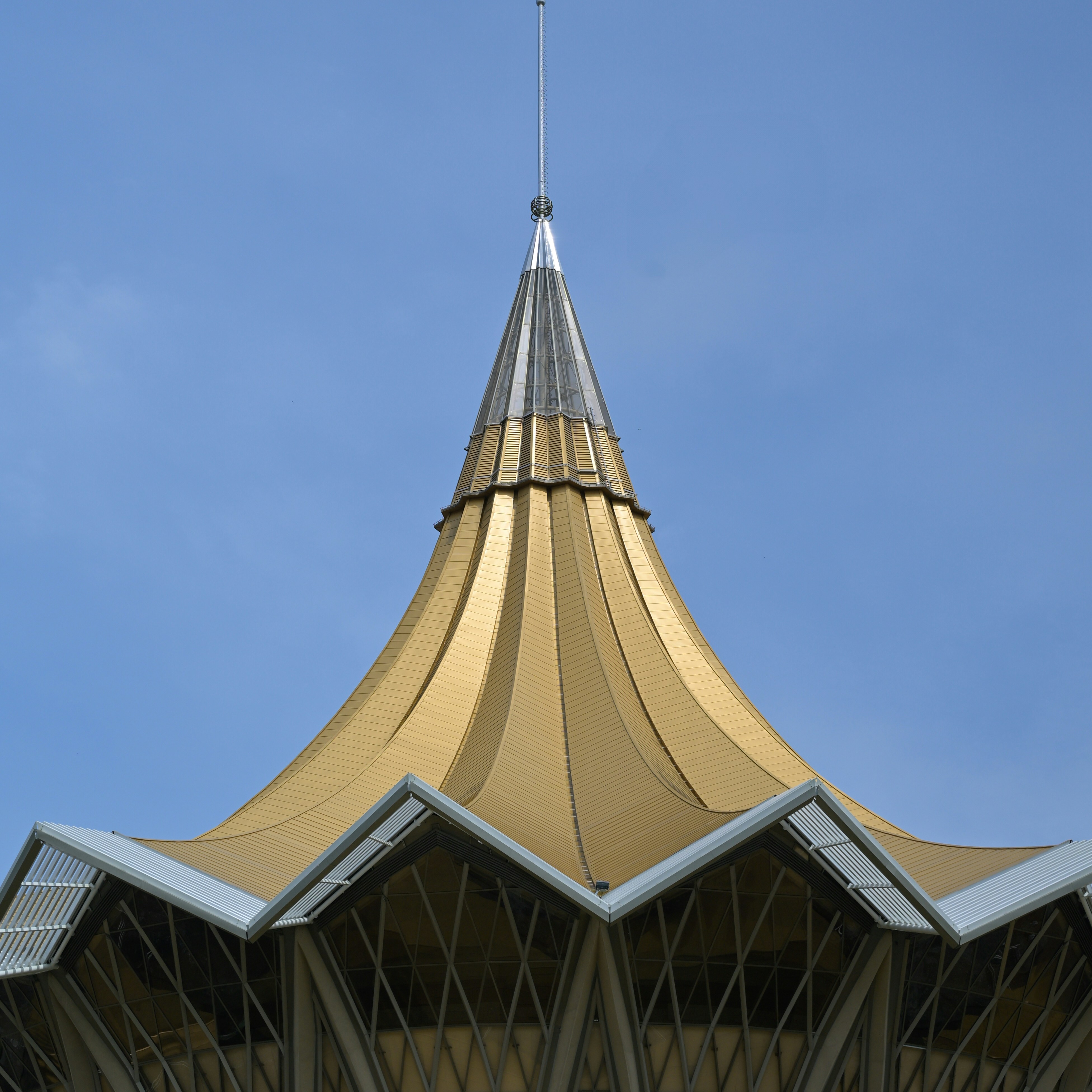 Golden Spire Crown Above Geometric Rooflines