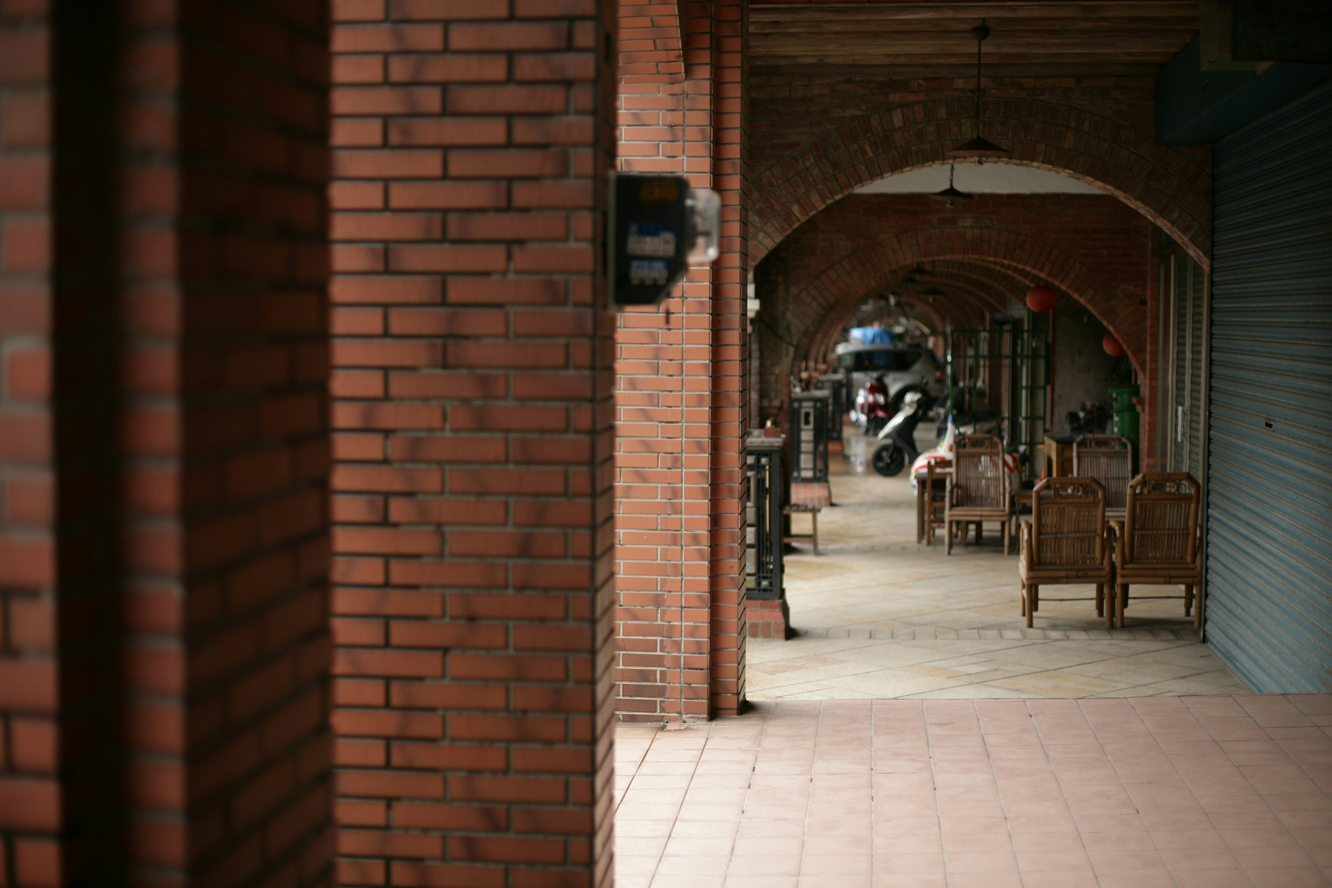 A brick walkway with arches and seating. photo – Free Car Image on Unsplash