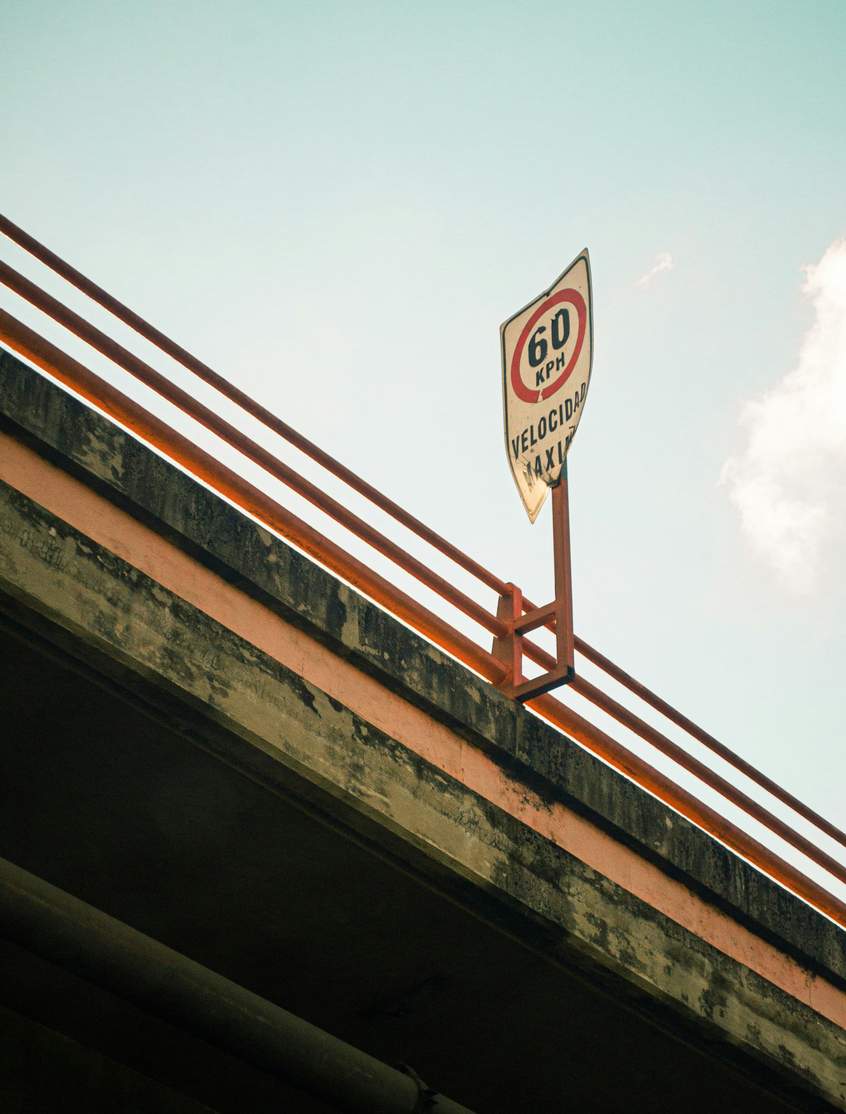 A speed limit sign sits atop a bridge. photo – Free Bridge Image on ...